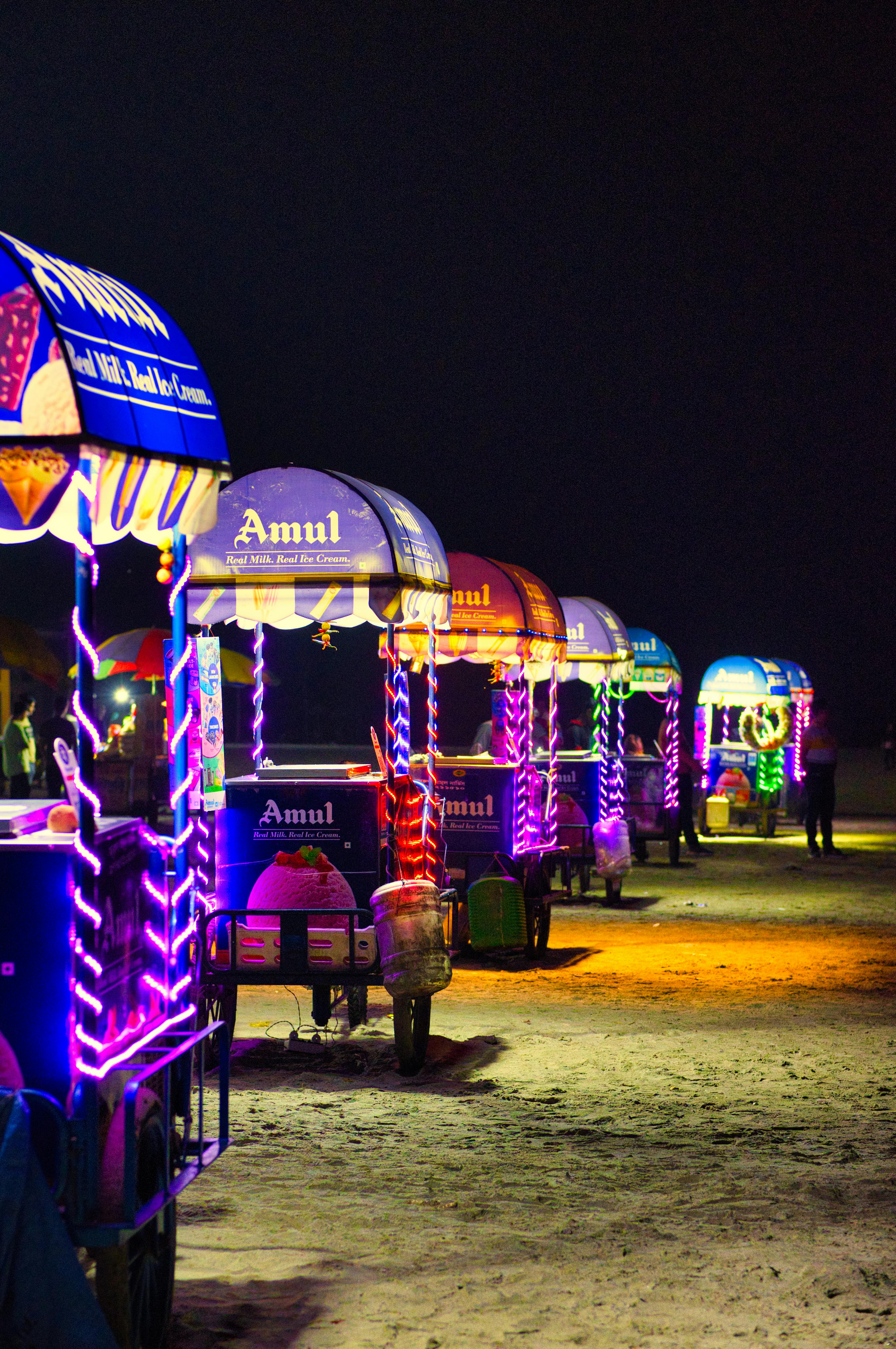 Illuminated Mobile Vending Stalls on Night Beach · Free Stock Photo