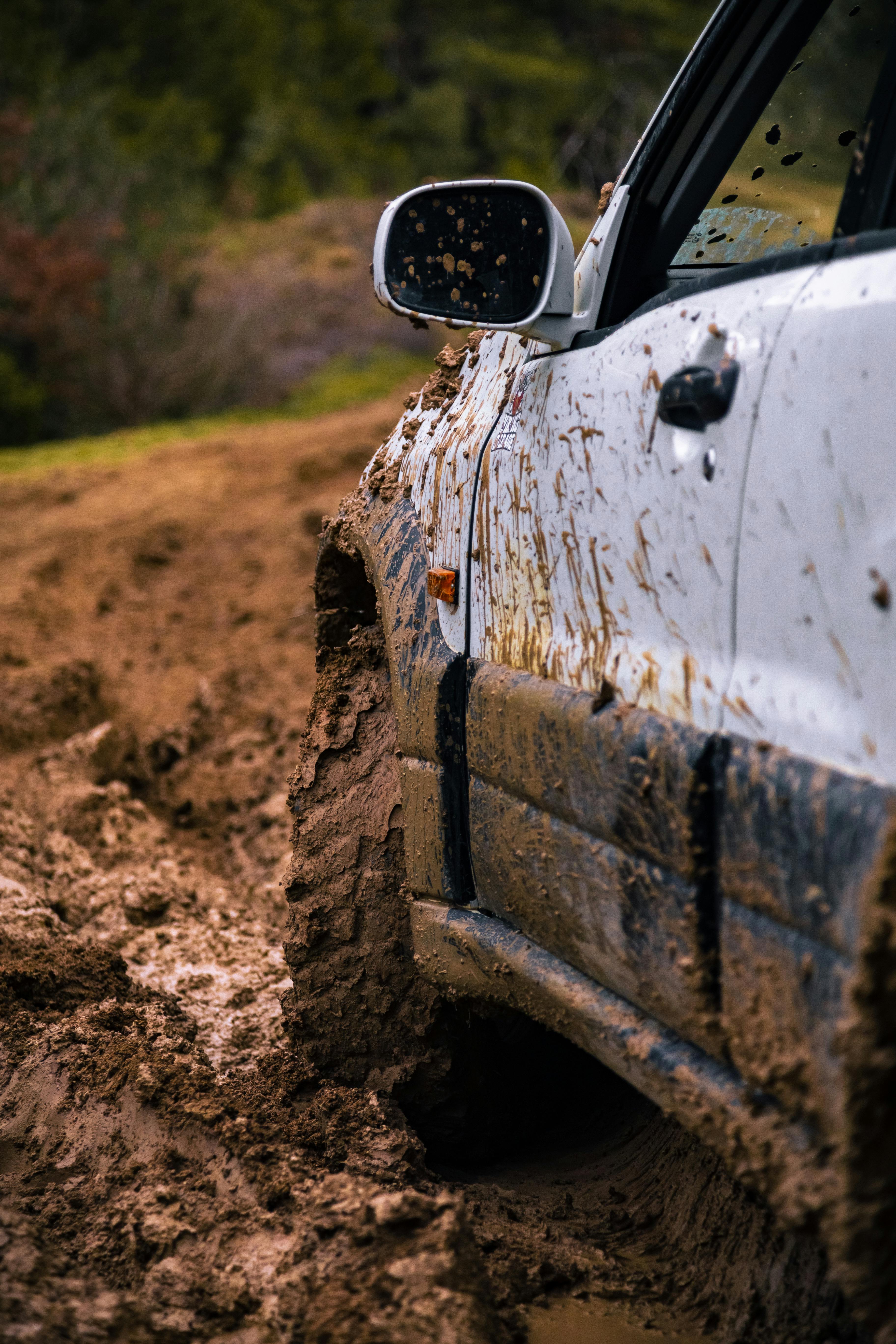 Red Car on Muddy Road Near Trees · Free Stock Photo