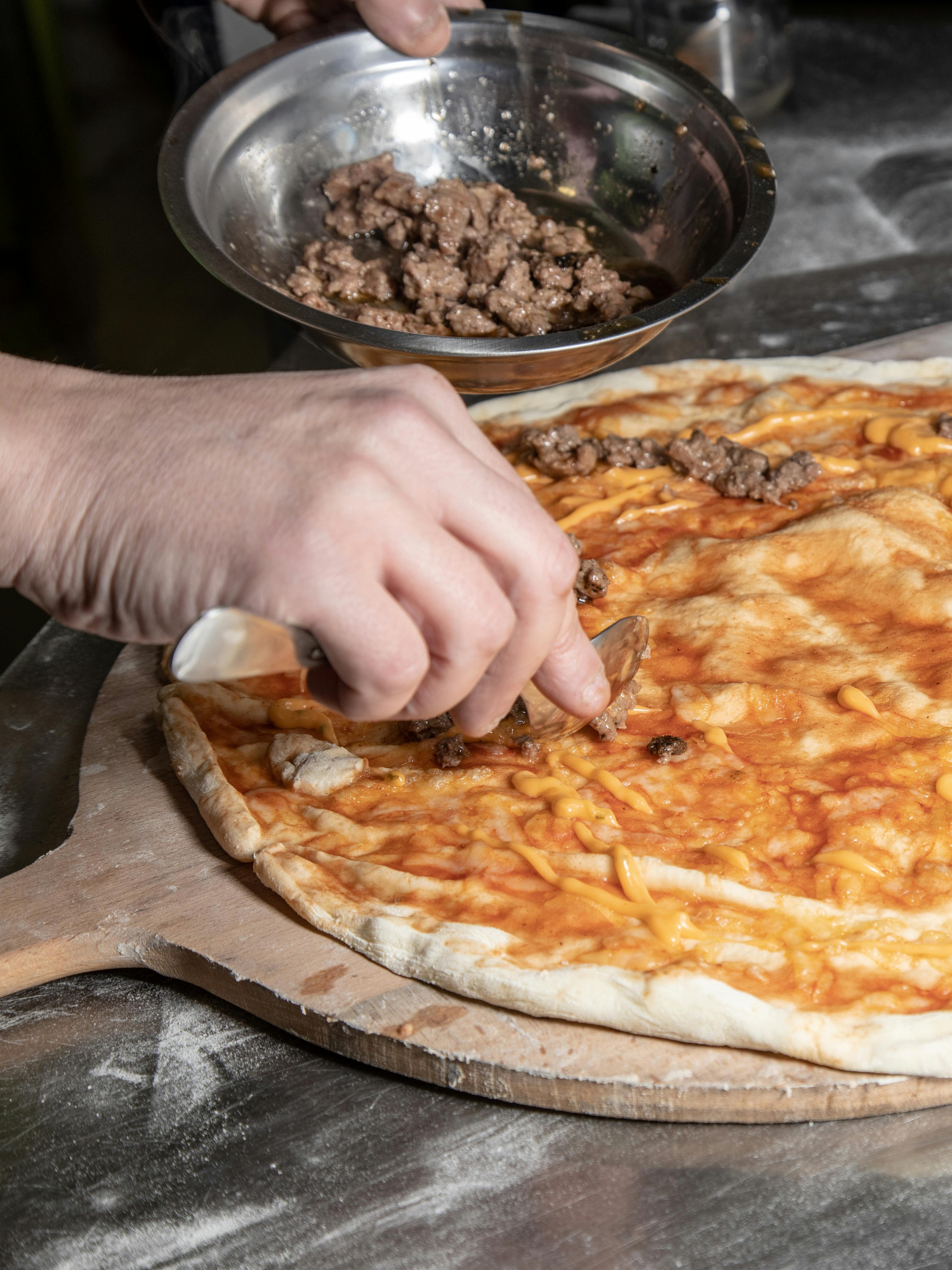 Stacking Topping on Pizza · Free Stock Photo