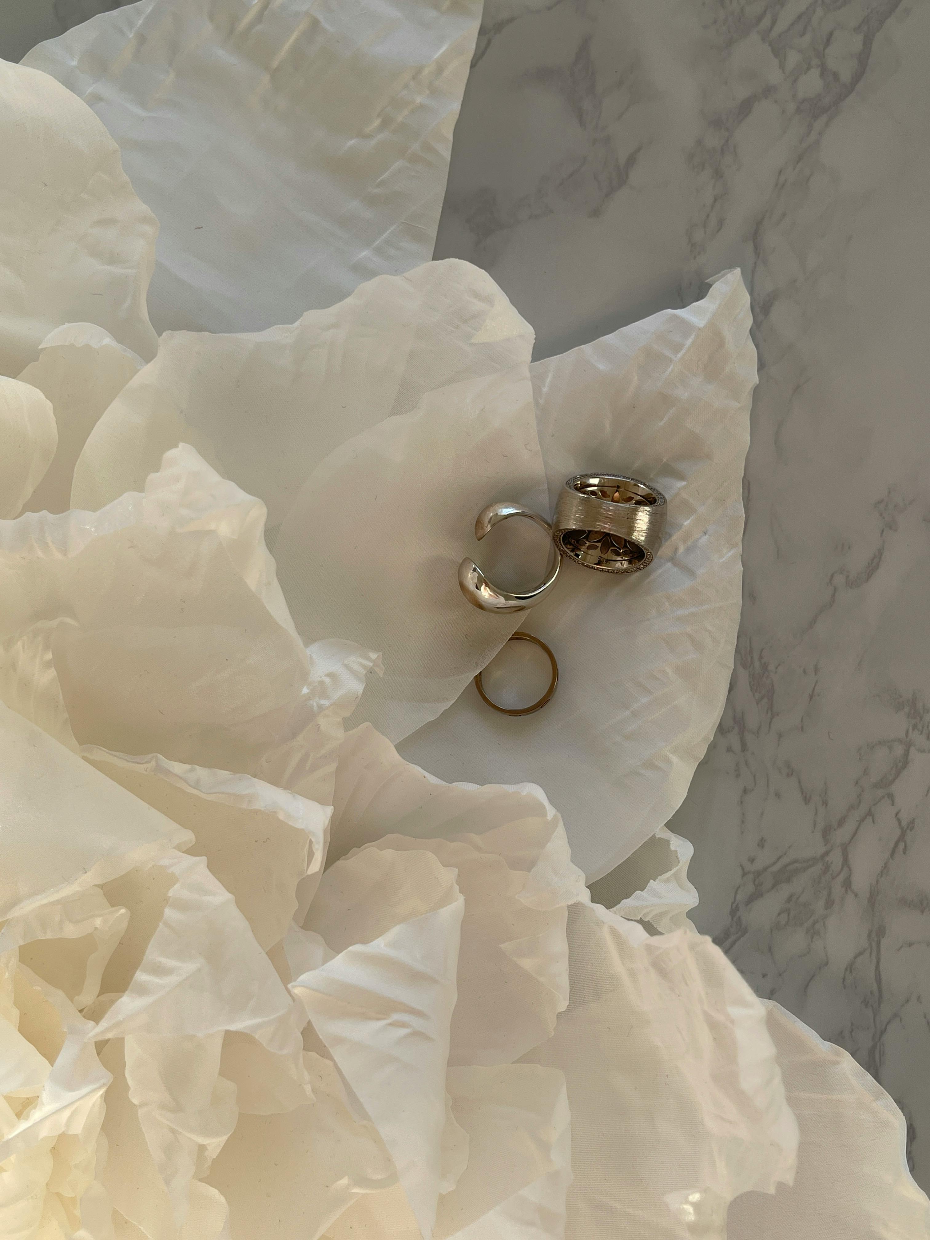Rings and Sheet of Paper on Marble Table · Free Stock Photo
