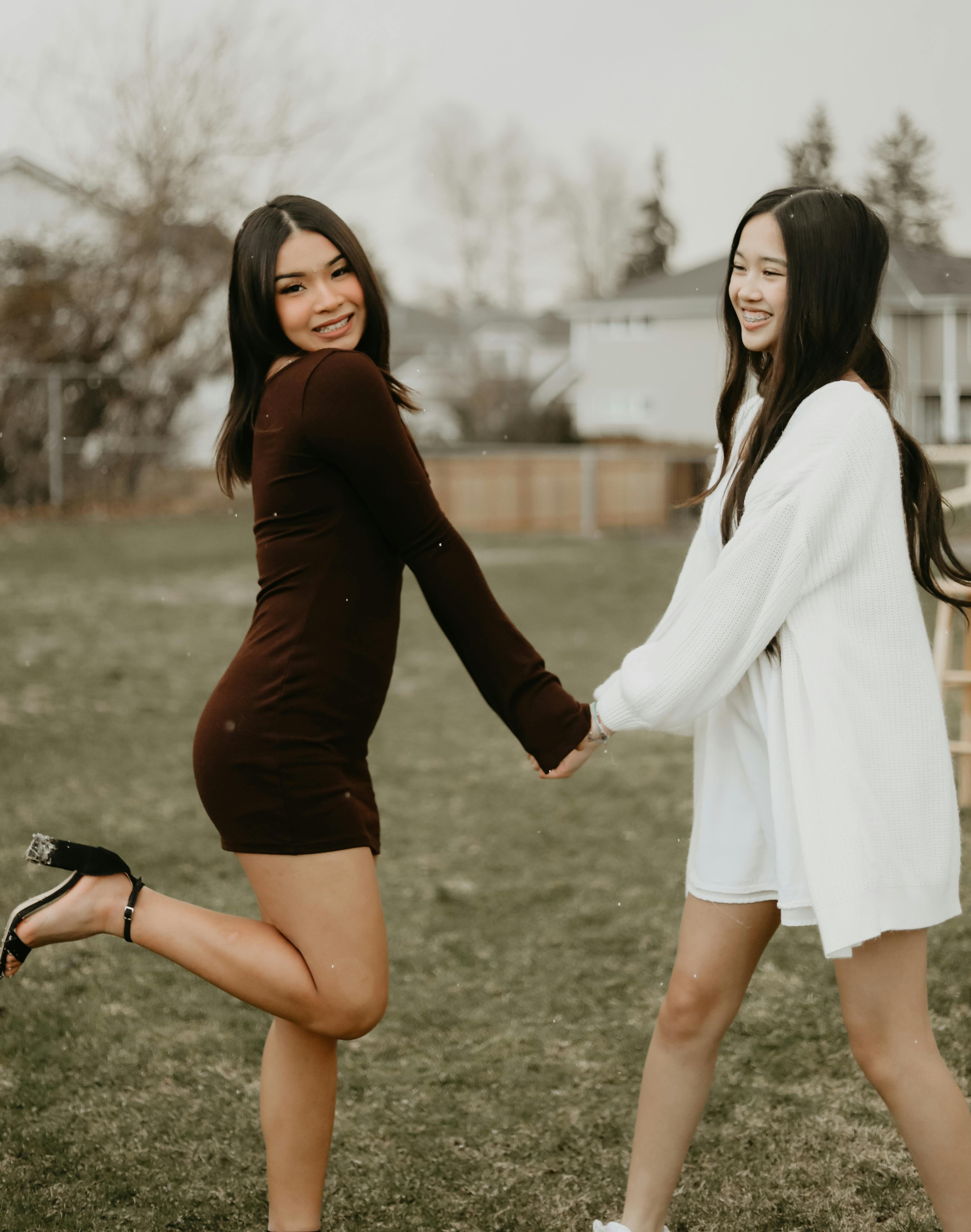 Beautiful Women in Dresses Holding Hands and Posing · Free Stock Photo