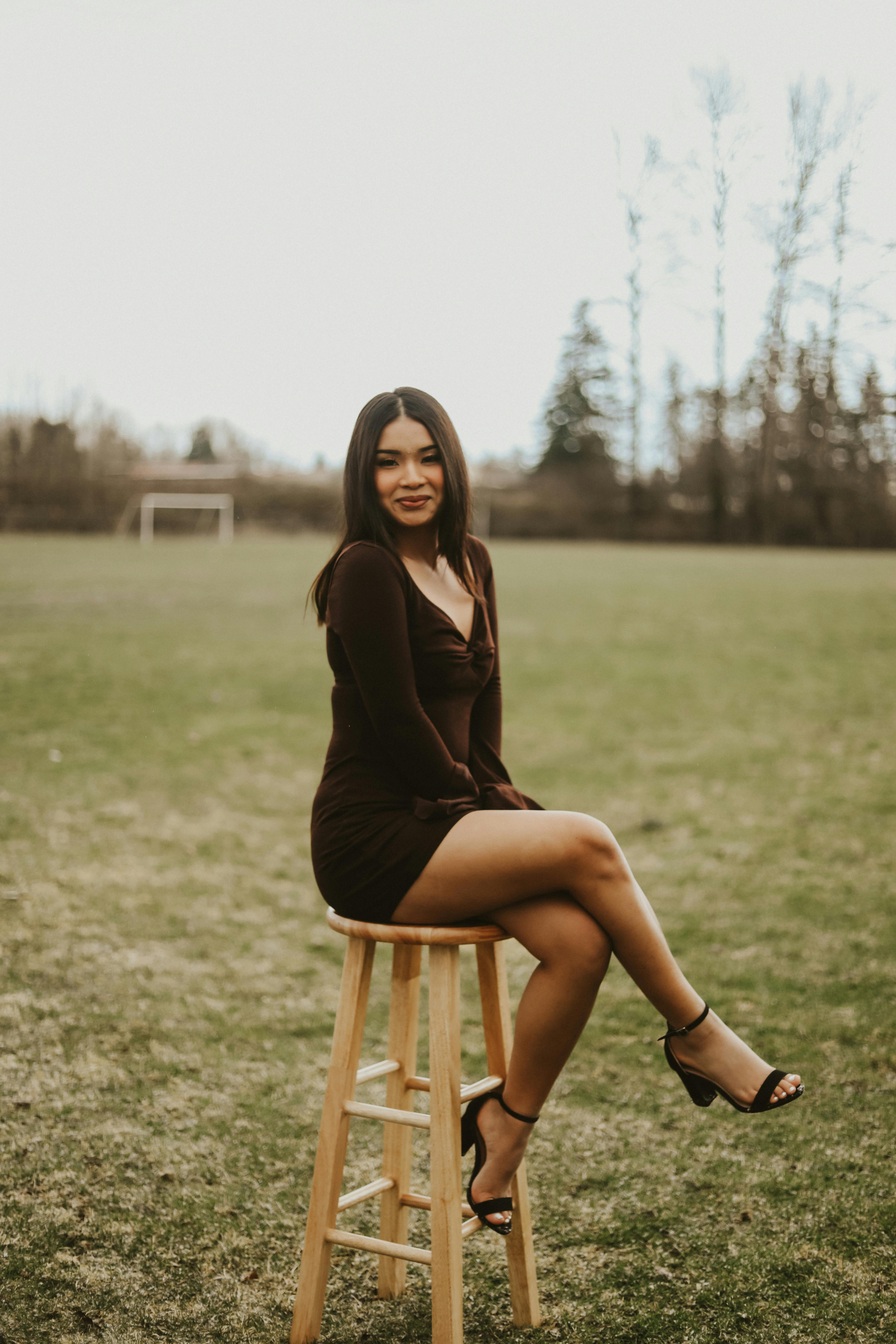 Woman Sitting on Stool With Legs Crossed · Free Stock Photo
