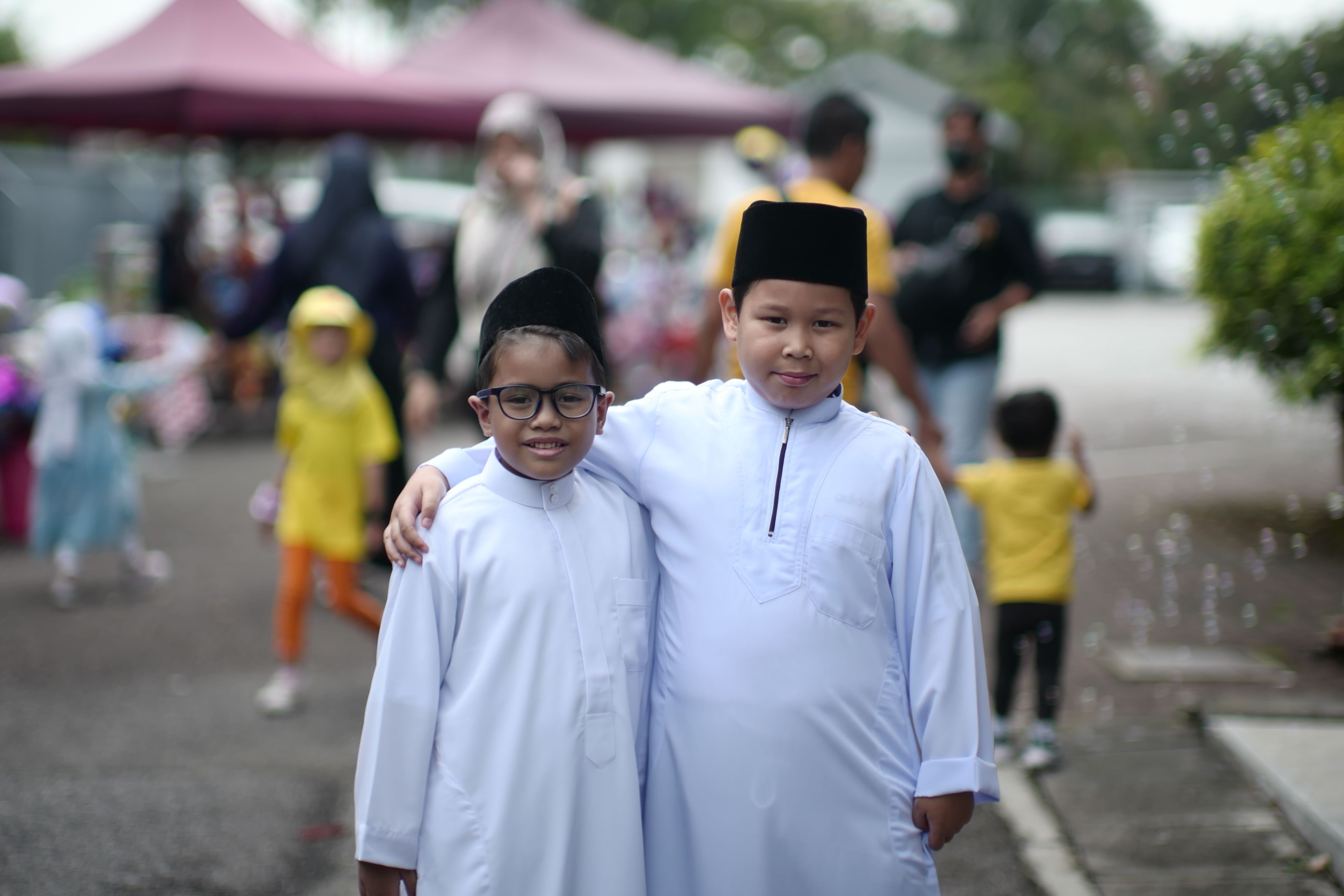 Two Boys Posing in White Robes and Black Kufi Hats · Free Stock Photo