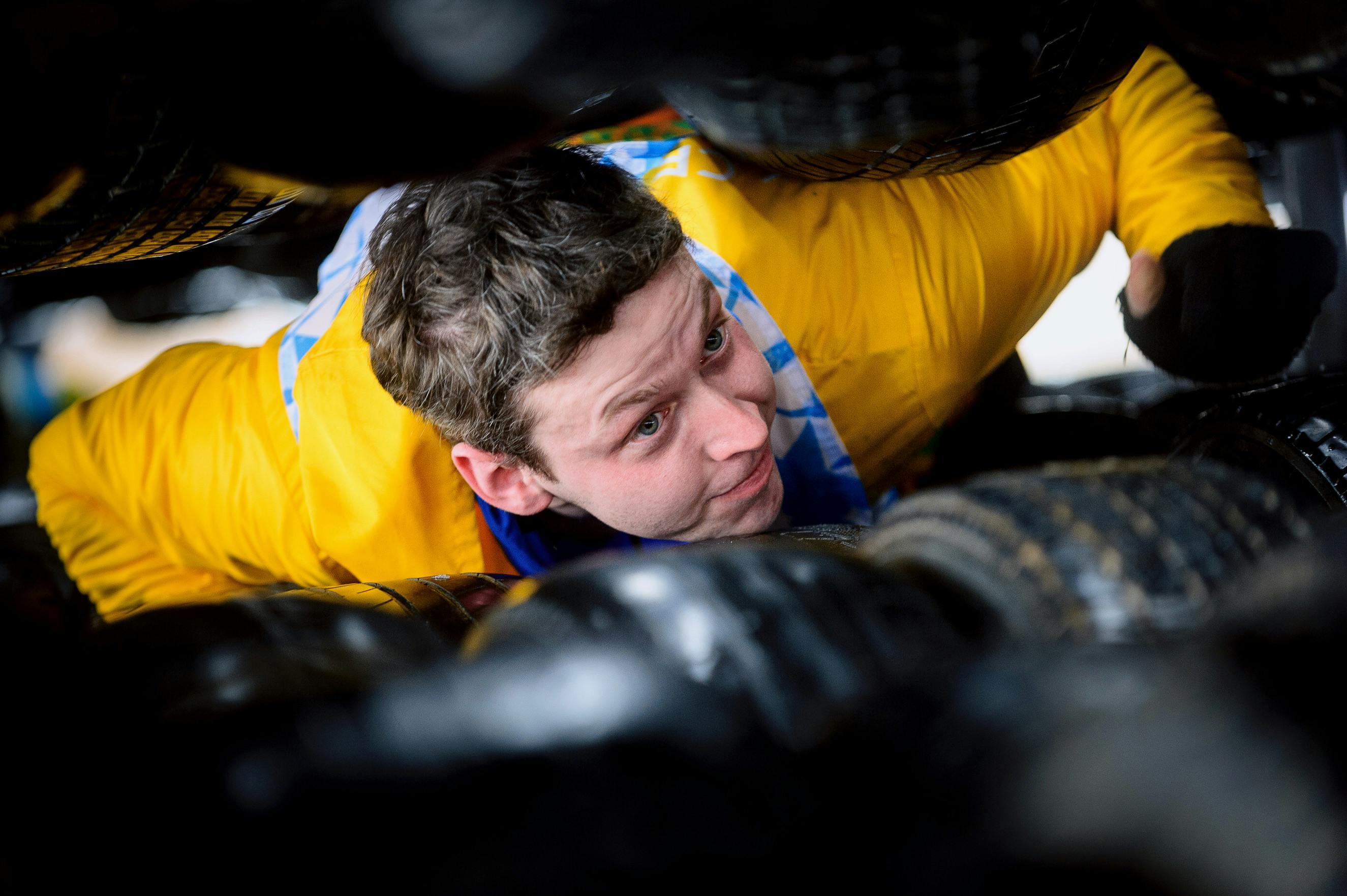 Man Squeezing between Tires · Free Stock Photo