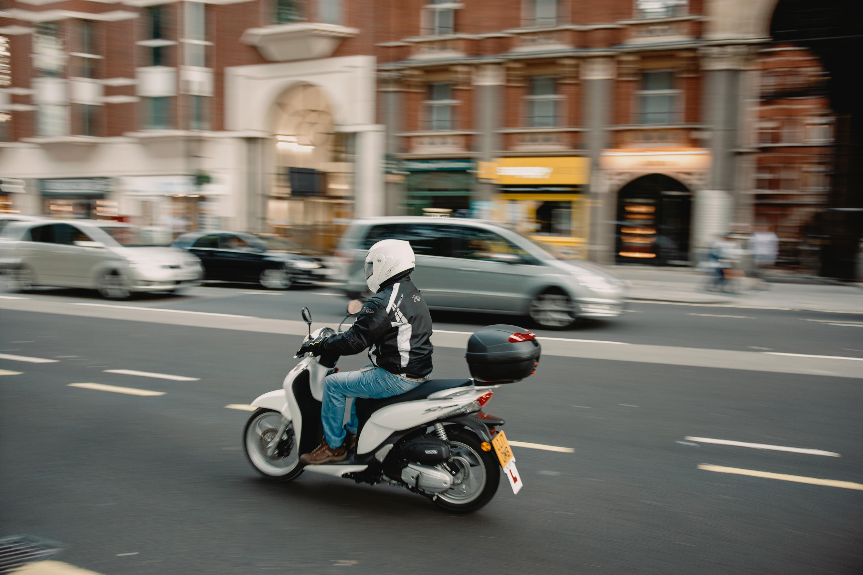 Person Riding on Yellow Motor Scooter on Road · Free Stock Photo