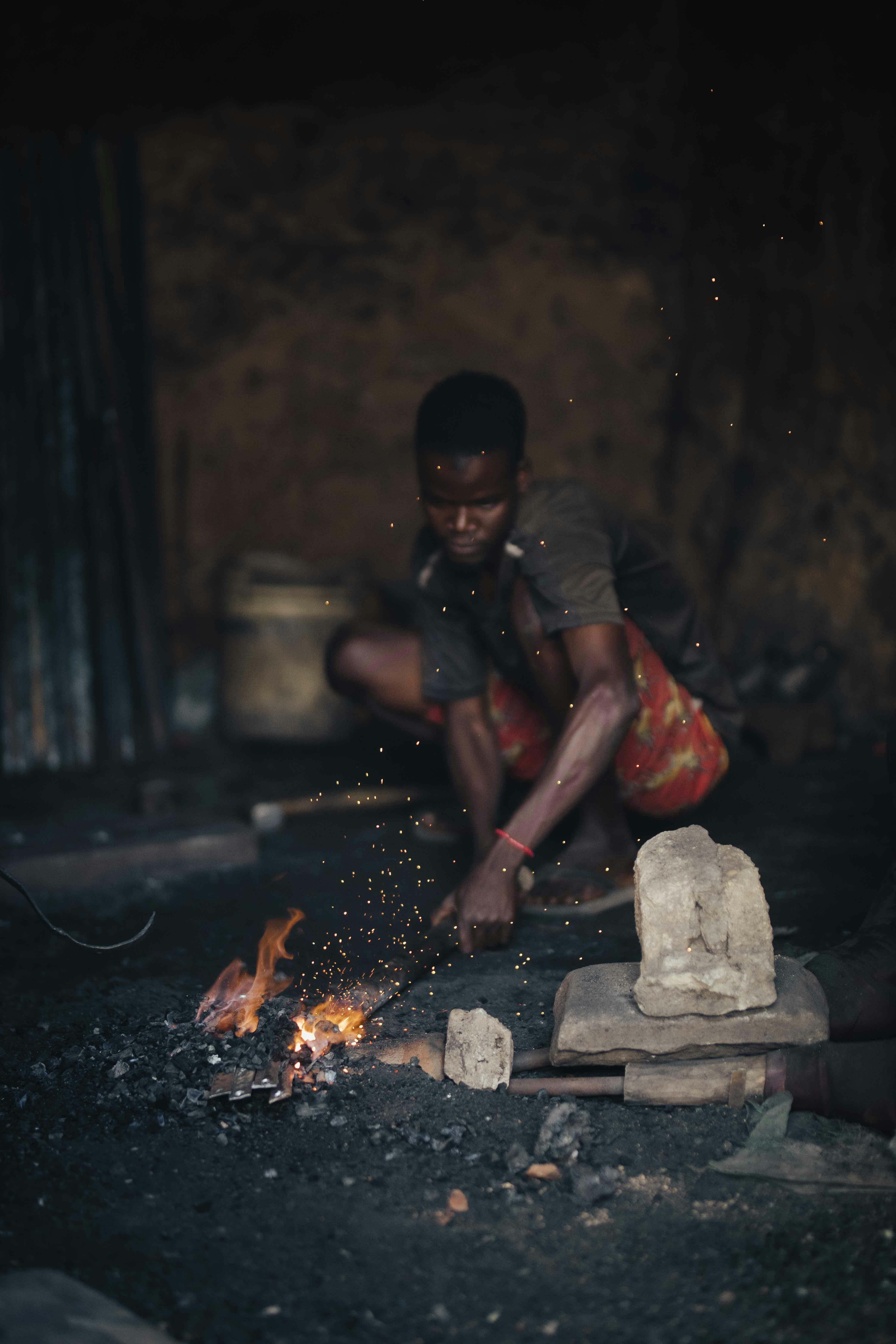 Boy Sitting by Bonfire in Hut · Free Stock Photo