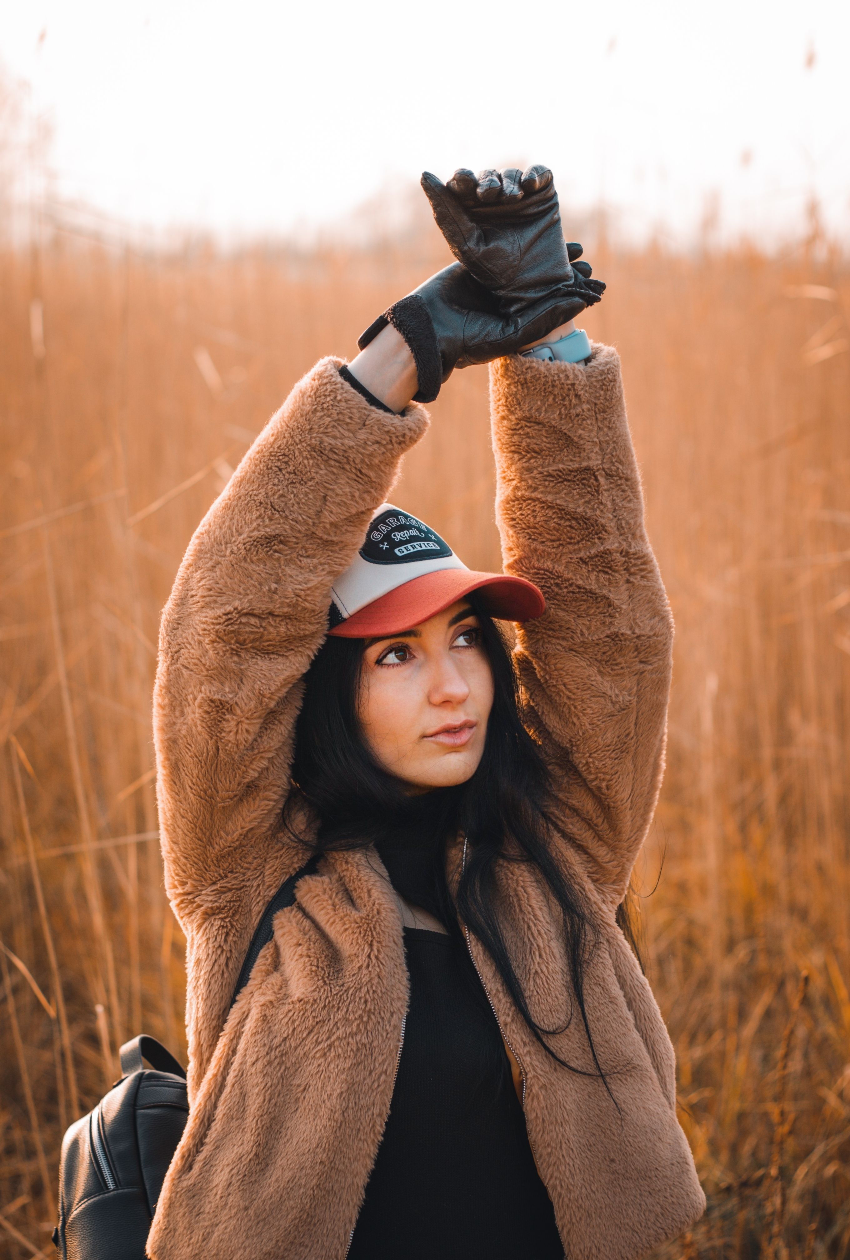 Brunette Woman in Jacket Posing with Raised Arms · Free Stock Photo