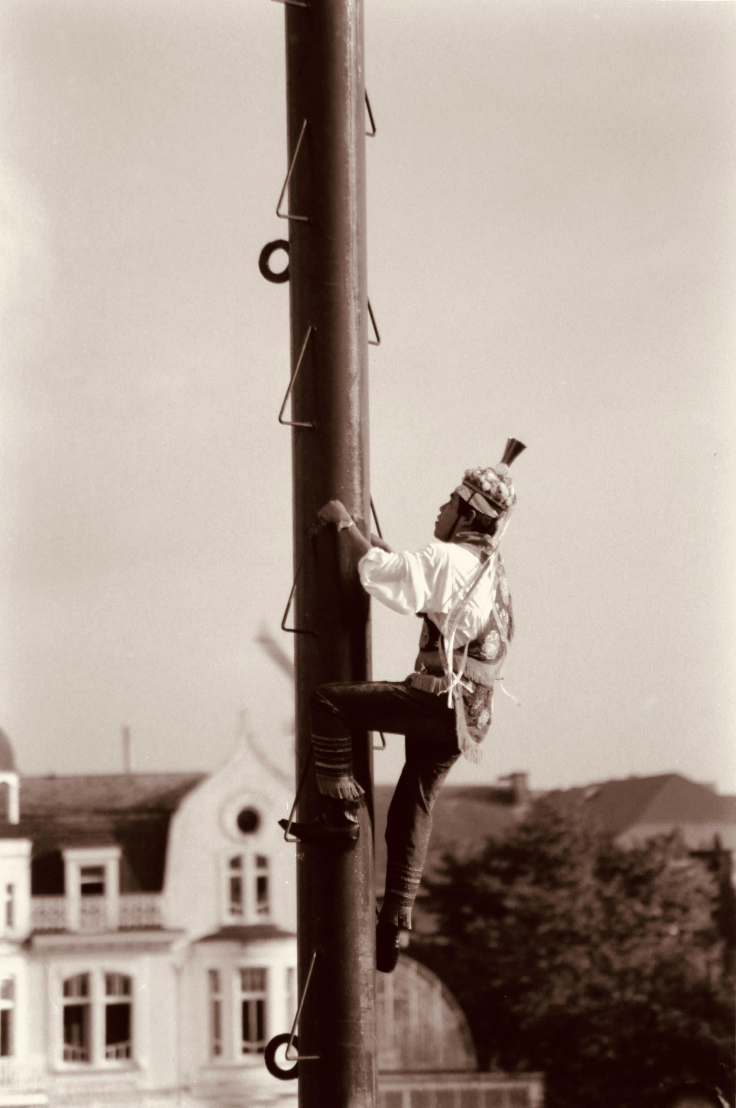 Man Climbing Pole in Town · Free Stock Photo