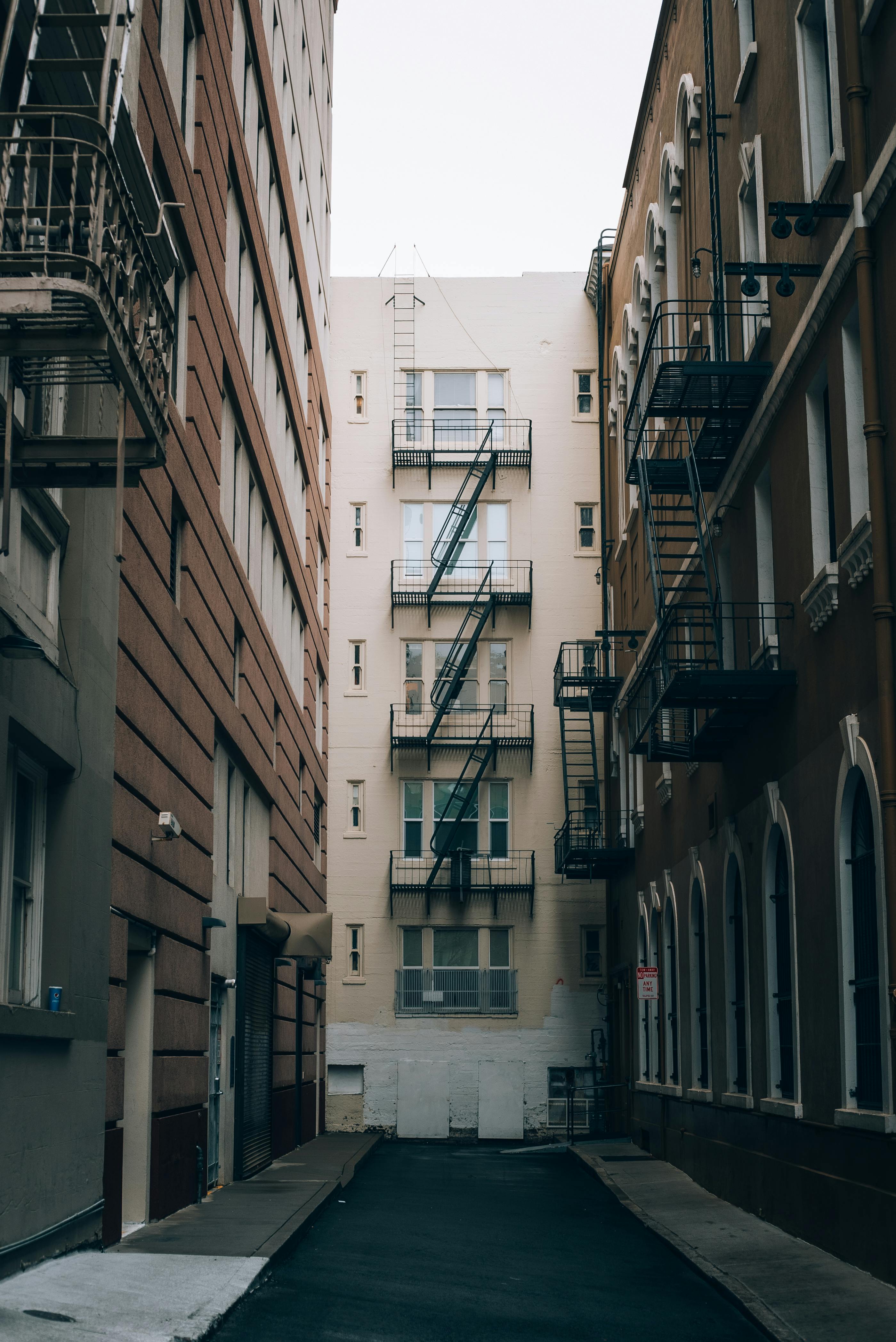 An alley with buildings and a fire escape · Free Stock Photo