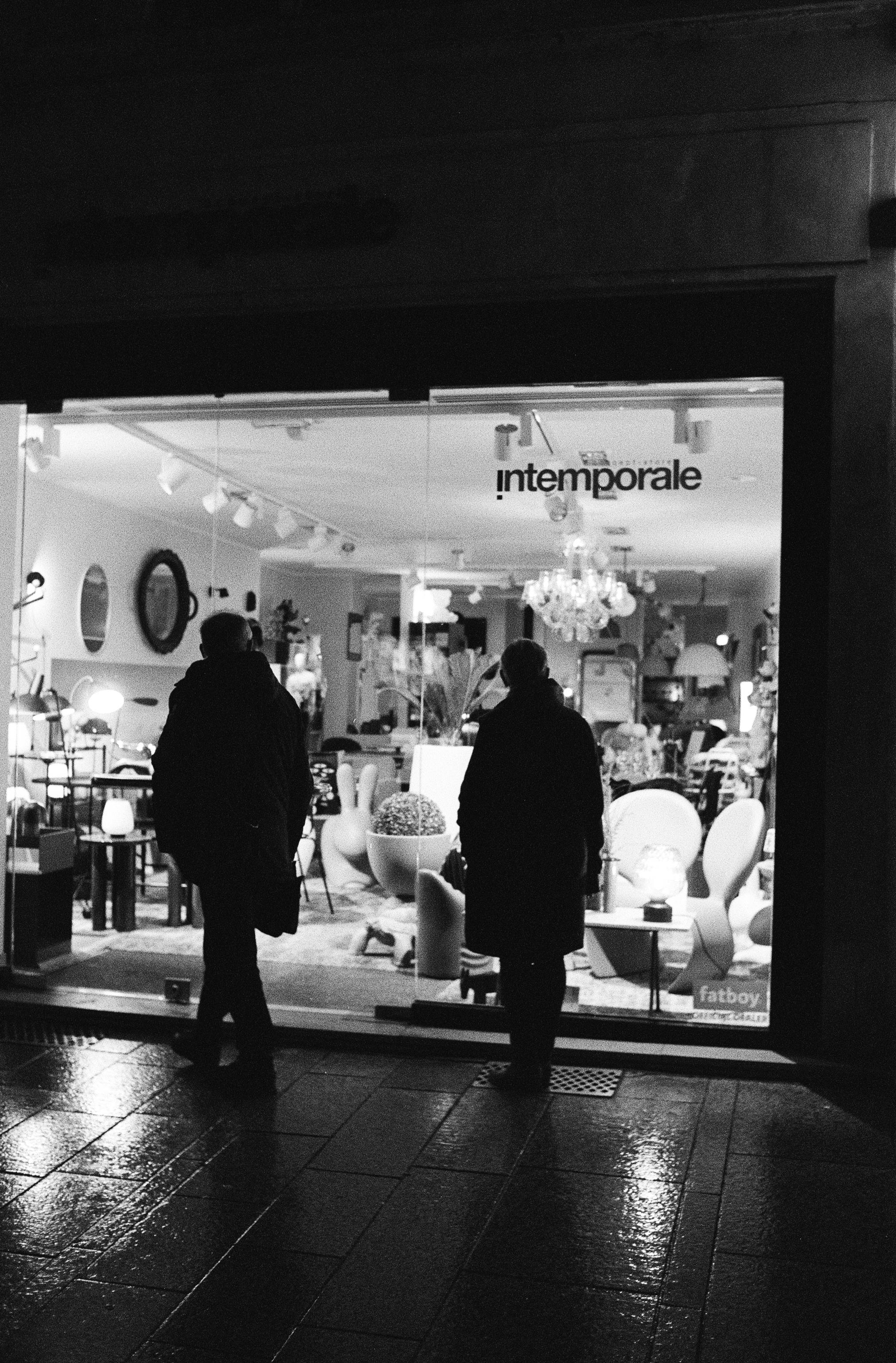 People Looking Through Storefront · Free Stock Photo