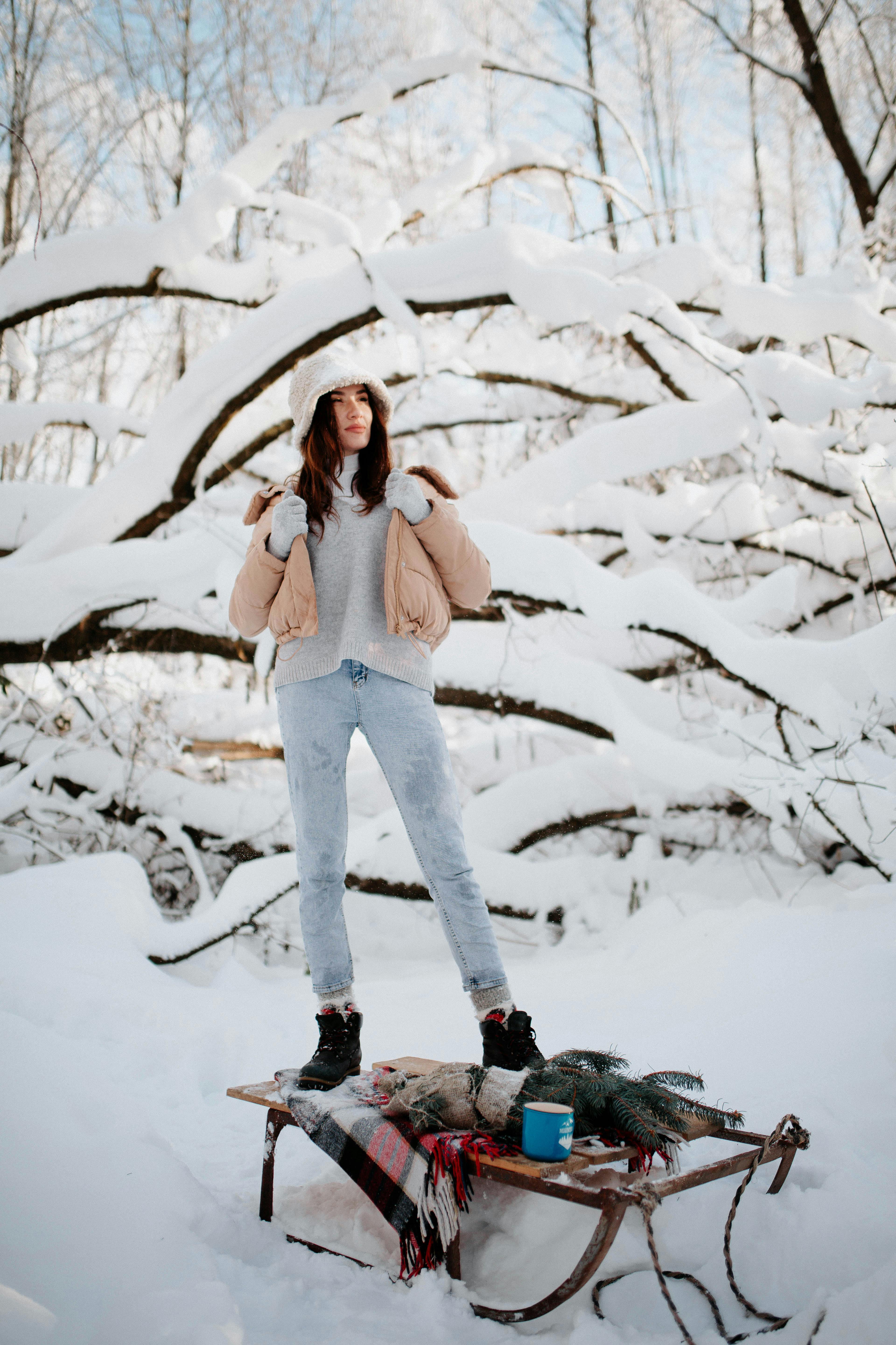 Woman Standing on a Sledge in a Snowy Landscape · Free Stock Photo