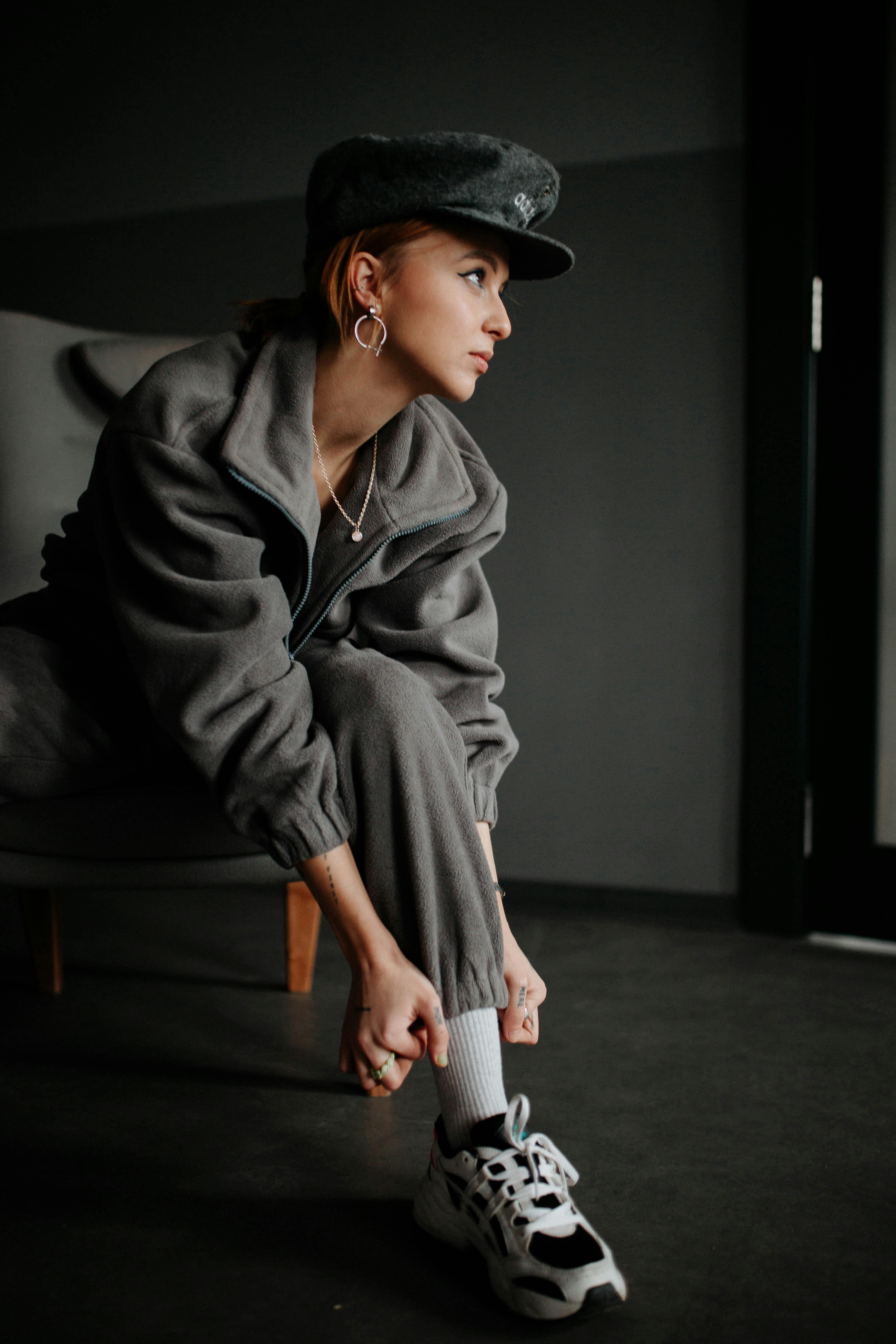 Woman Sitting and Pulling up Sock on Feet · Free Stock Photo