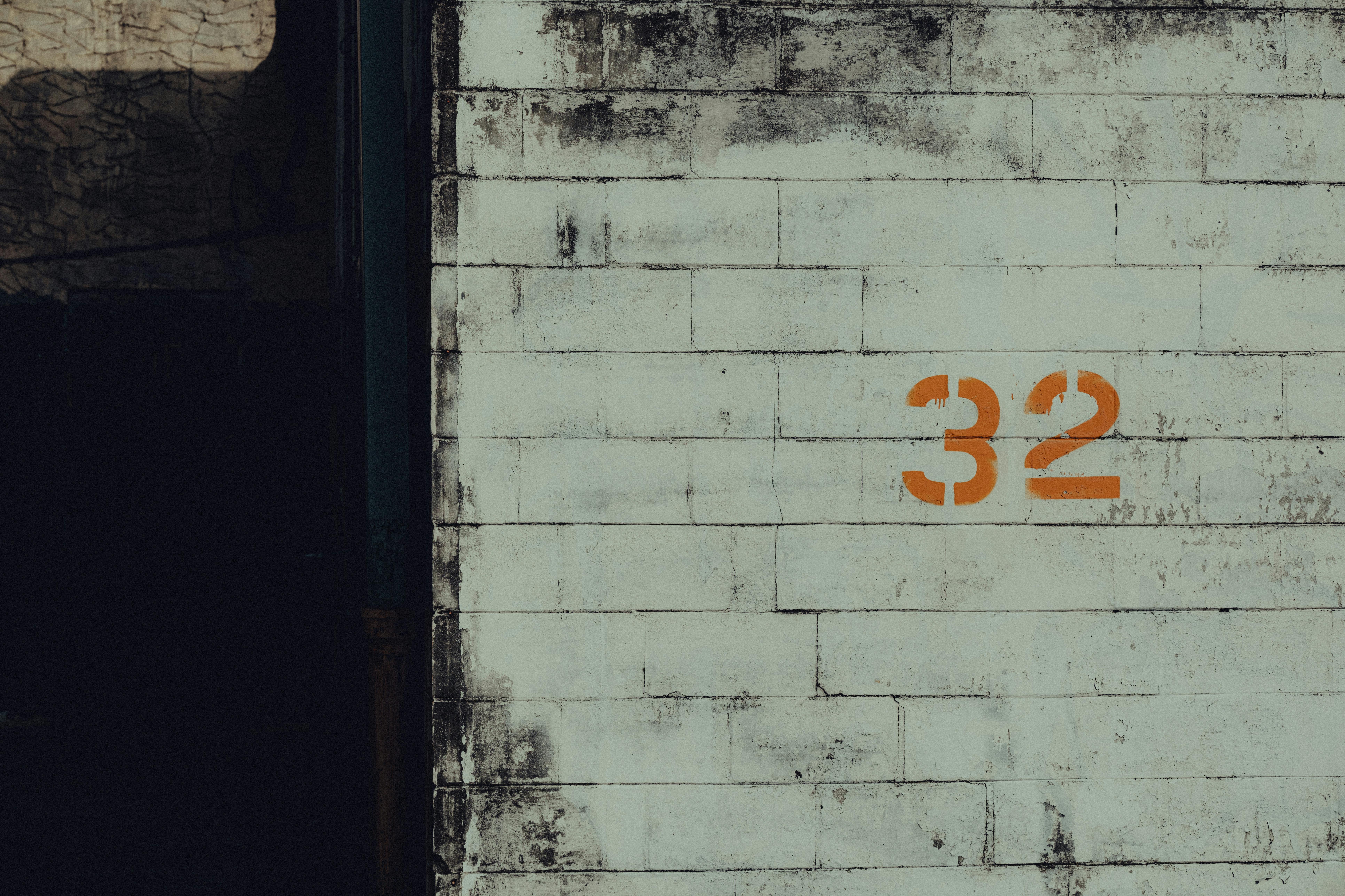 Number 32 Painted on White Brick Wall · Free Stock Photo