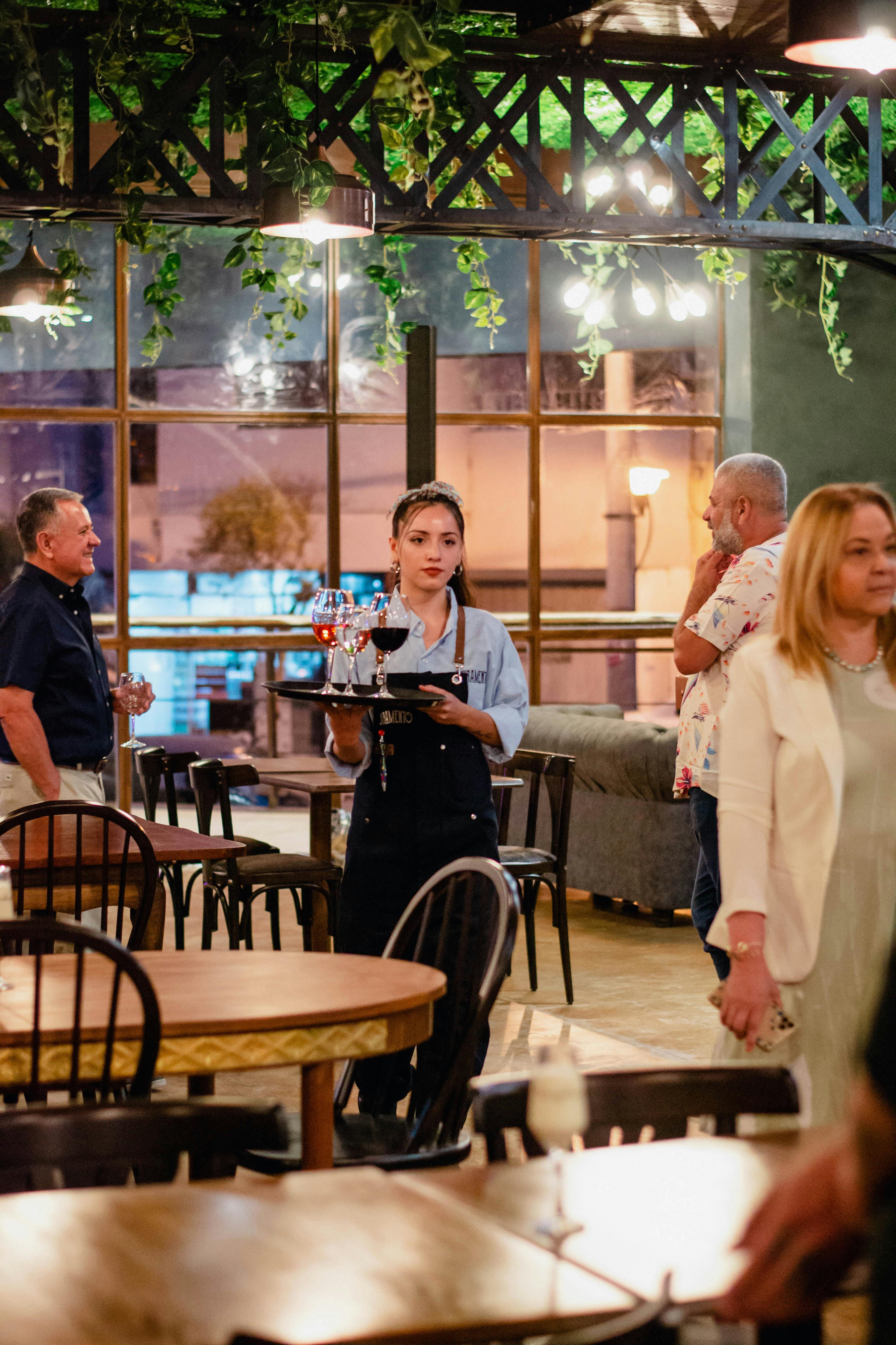 A Waitress Walking with a Tray with Wineglasses · Free Stock Photo