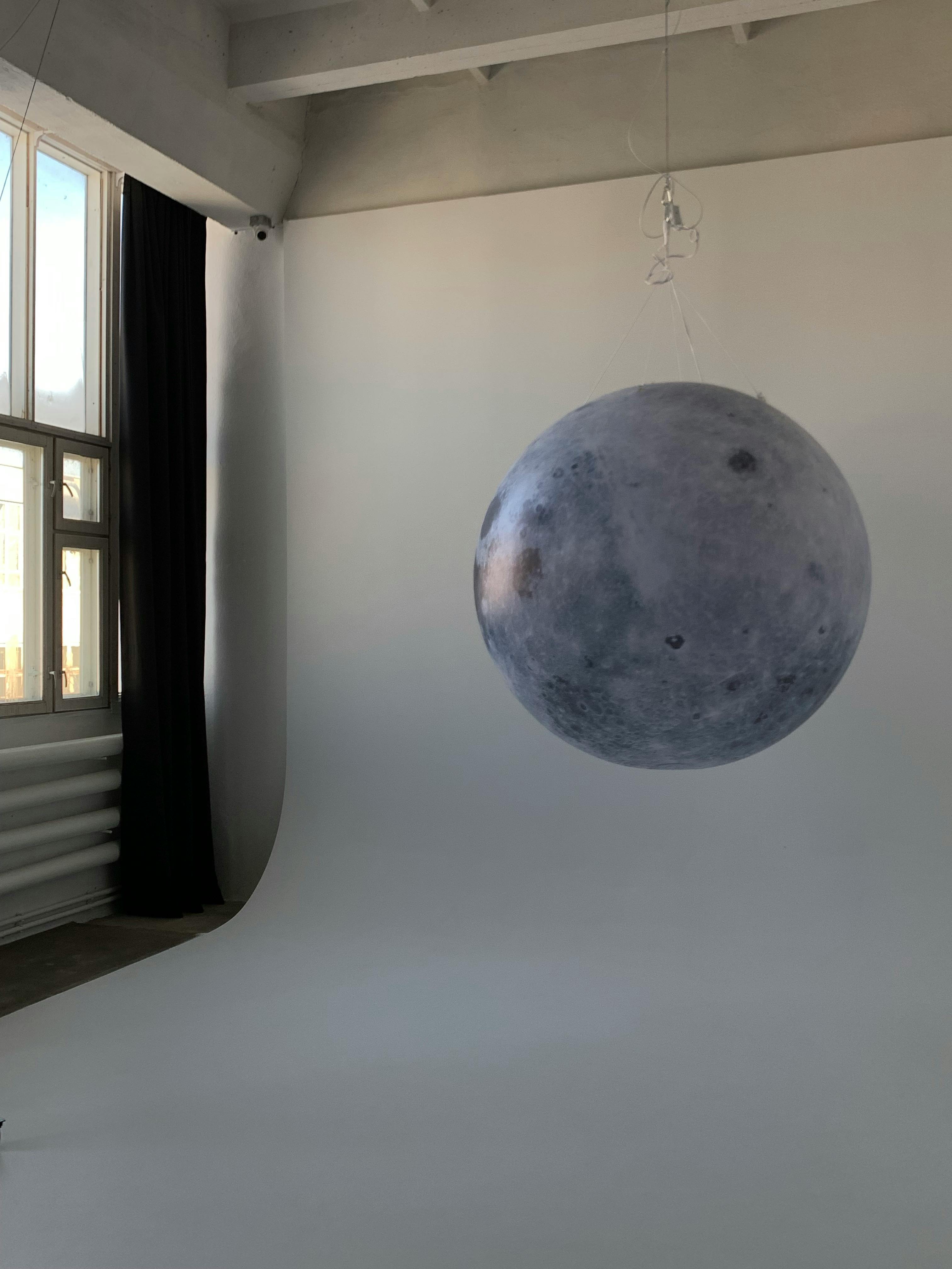 A Large Ball Shaped Decoration Hanging from a Ceiling in a Studio ...