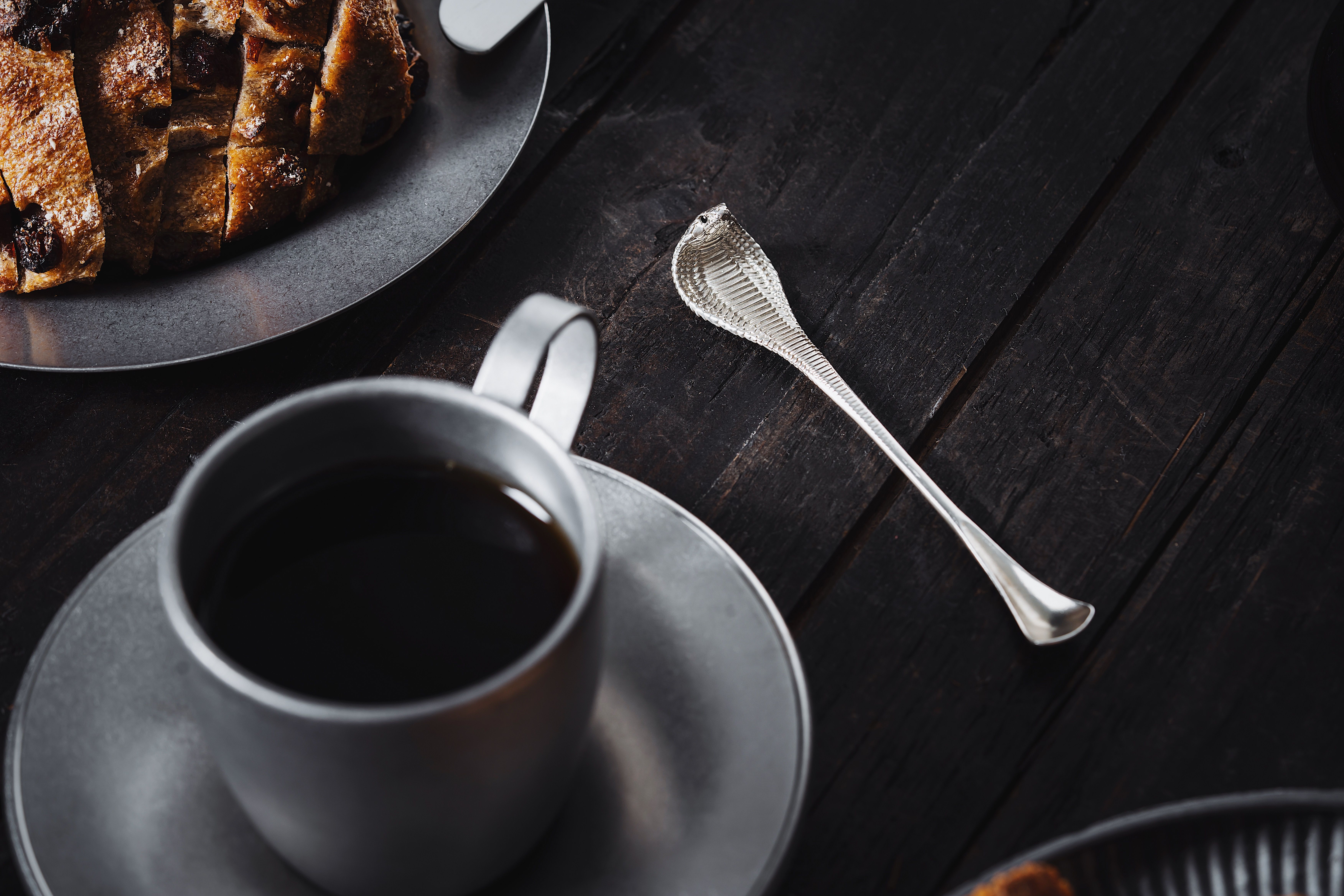 Silver Coffee Cup and a Cobra Spoon on a Table · Free Stock Photo