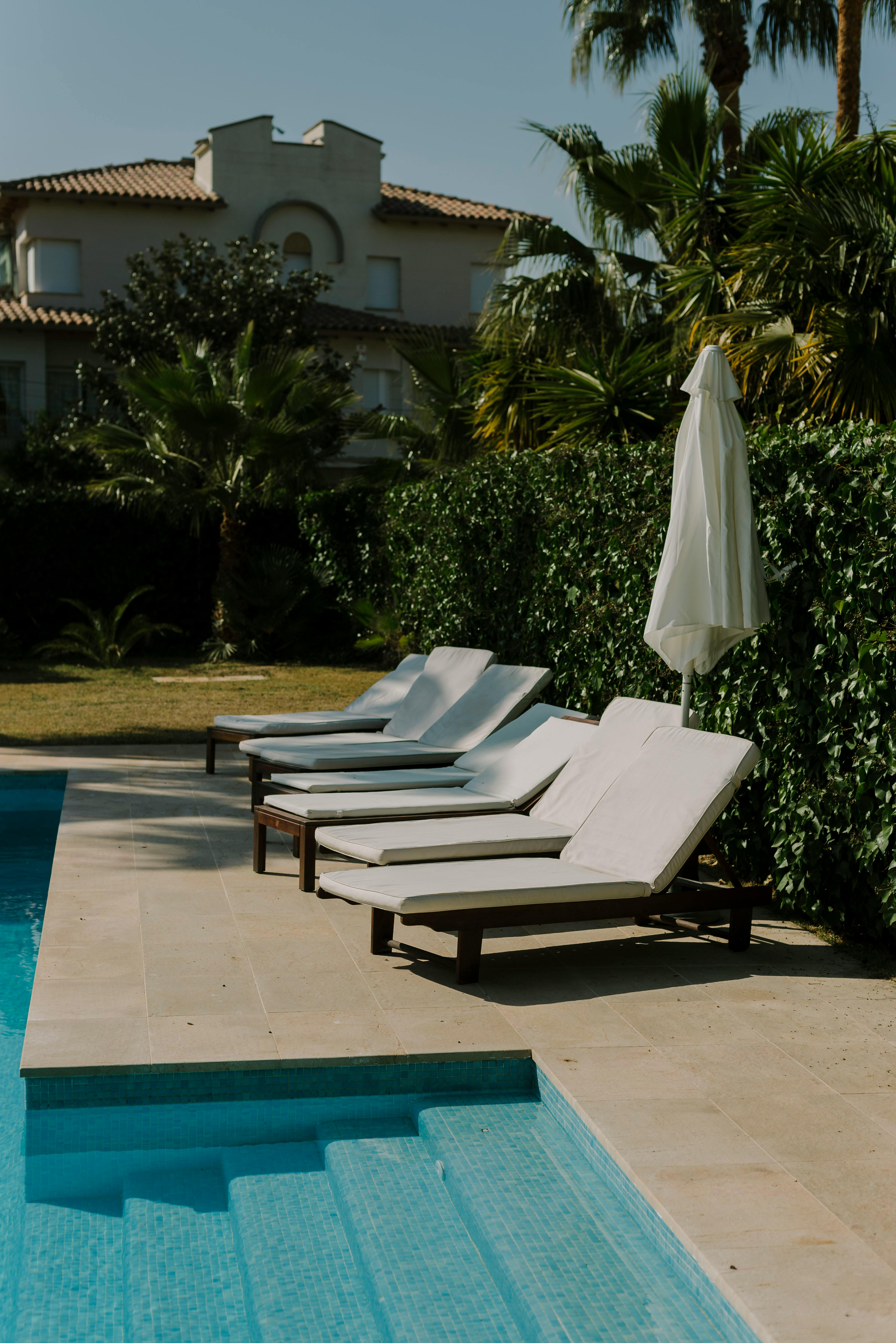 Lounge Chairs by a Swimming Pool · Free Stock Photo