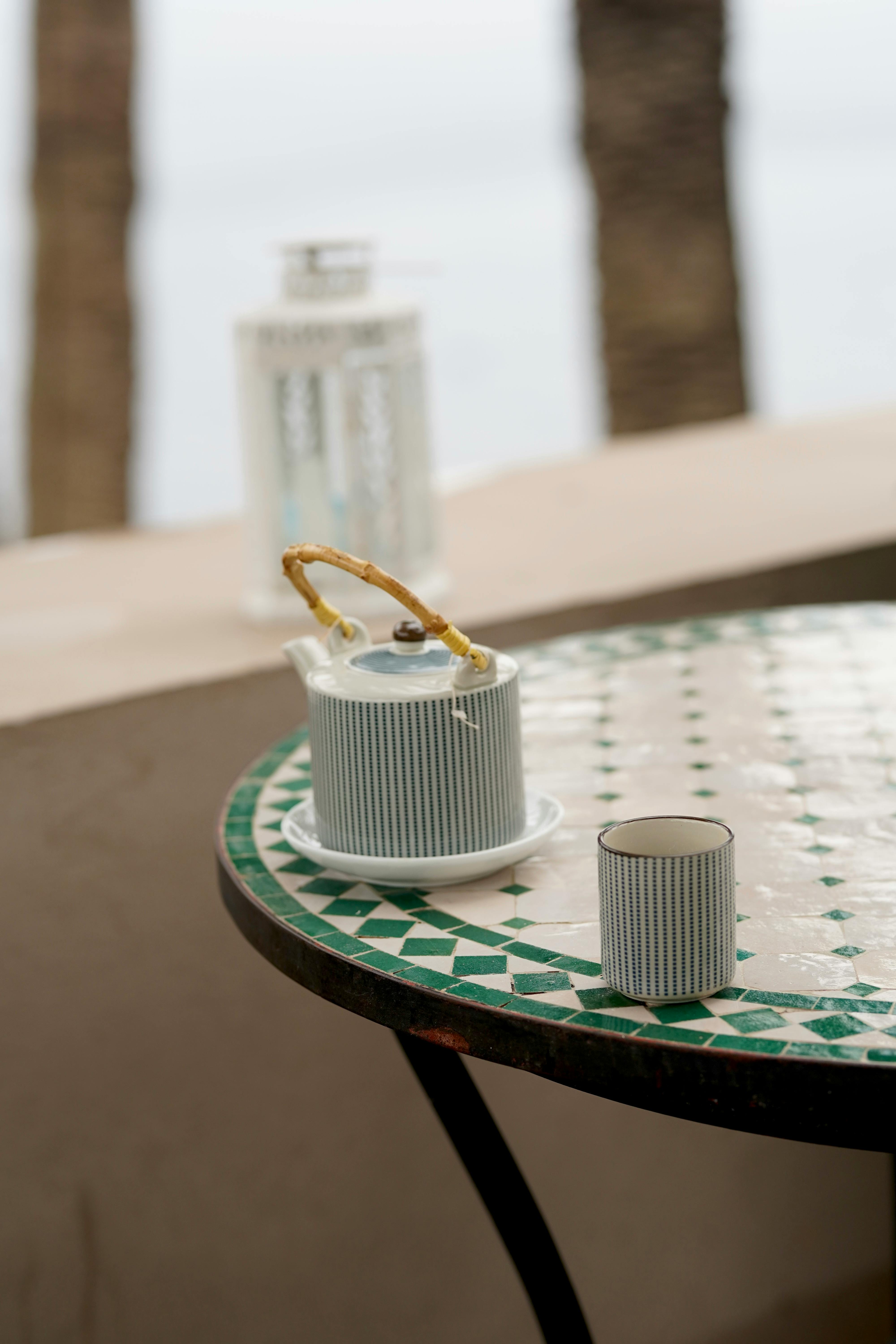 Comfortable chair near round table with newspaper and tea set · Free ...