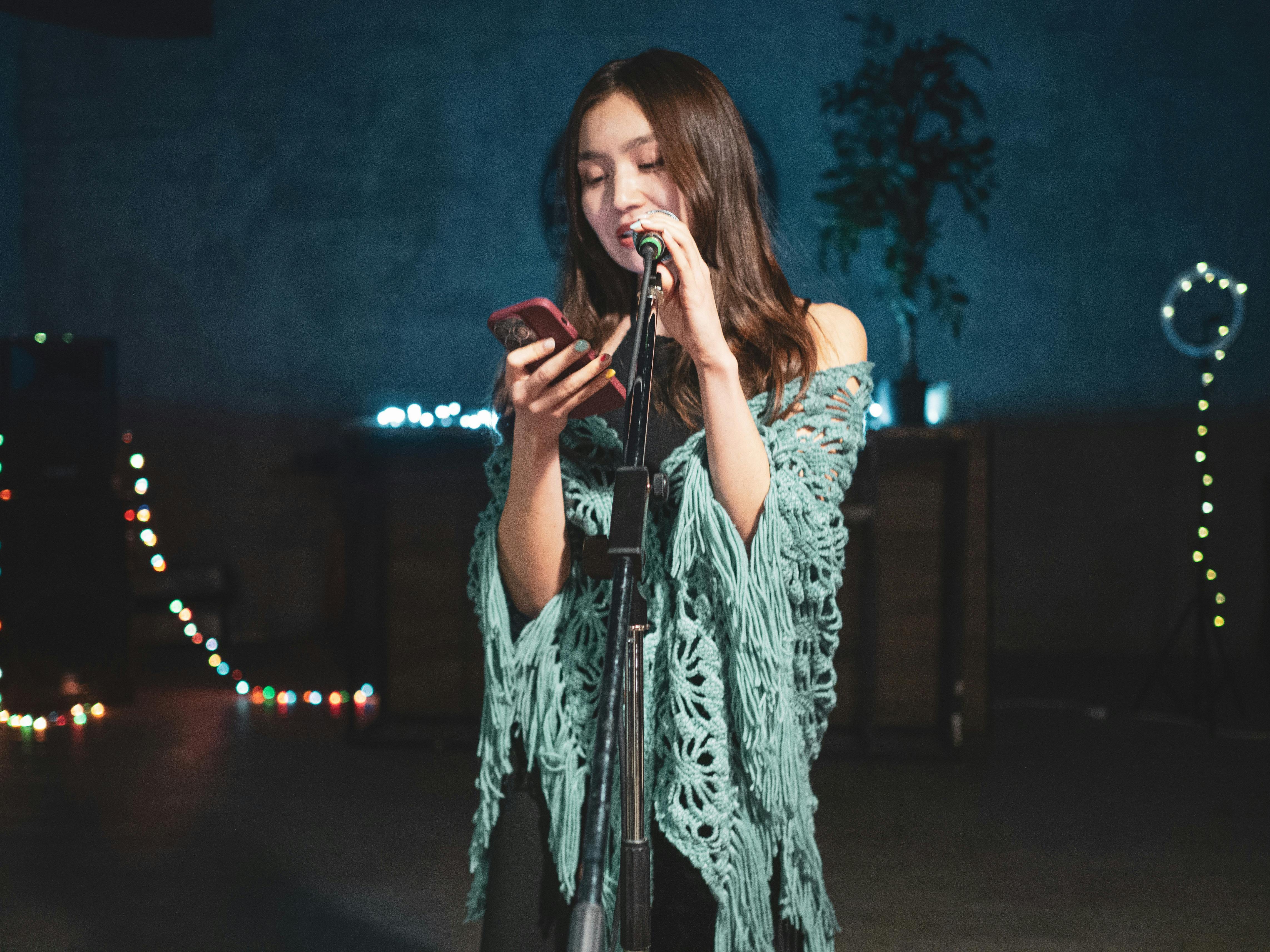 Female Singer Looking at her Phone · Free Stock Photo