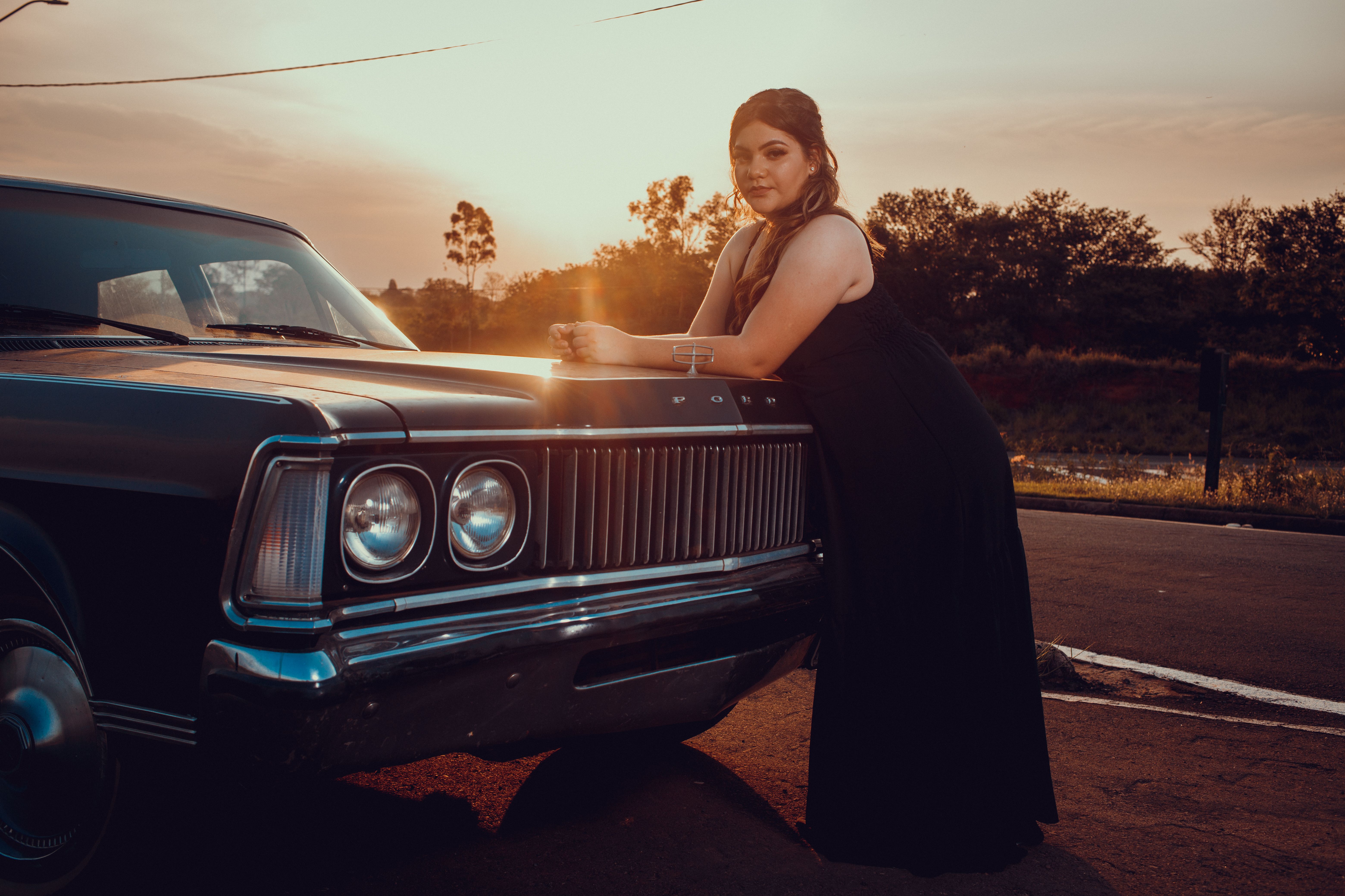 Sunlight over Woman Posing with Black Ford · Free Stock Photo