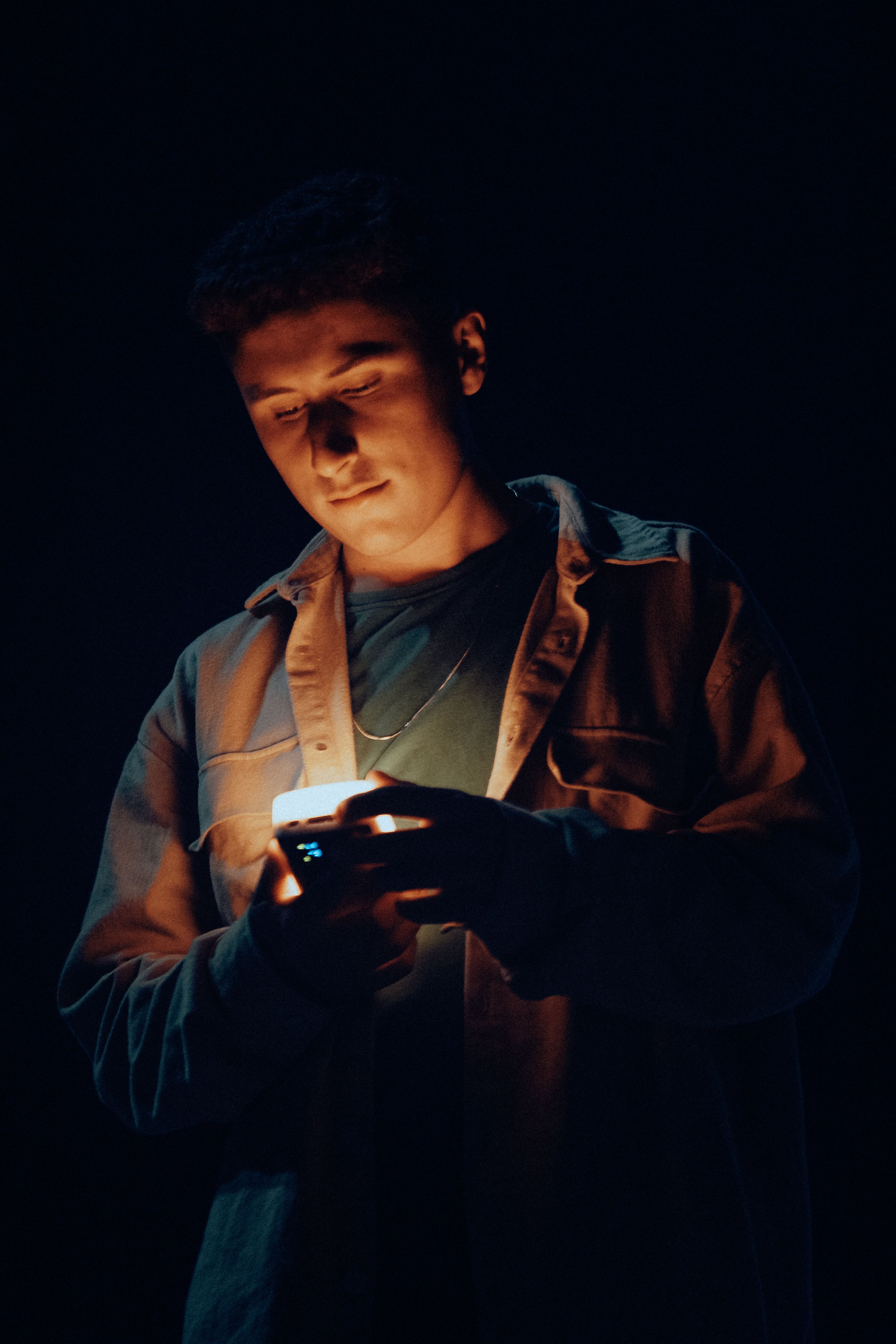Man in the Dark with his Face Illuminated by the Phone · Free Stock Photo