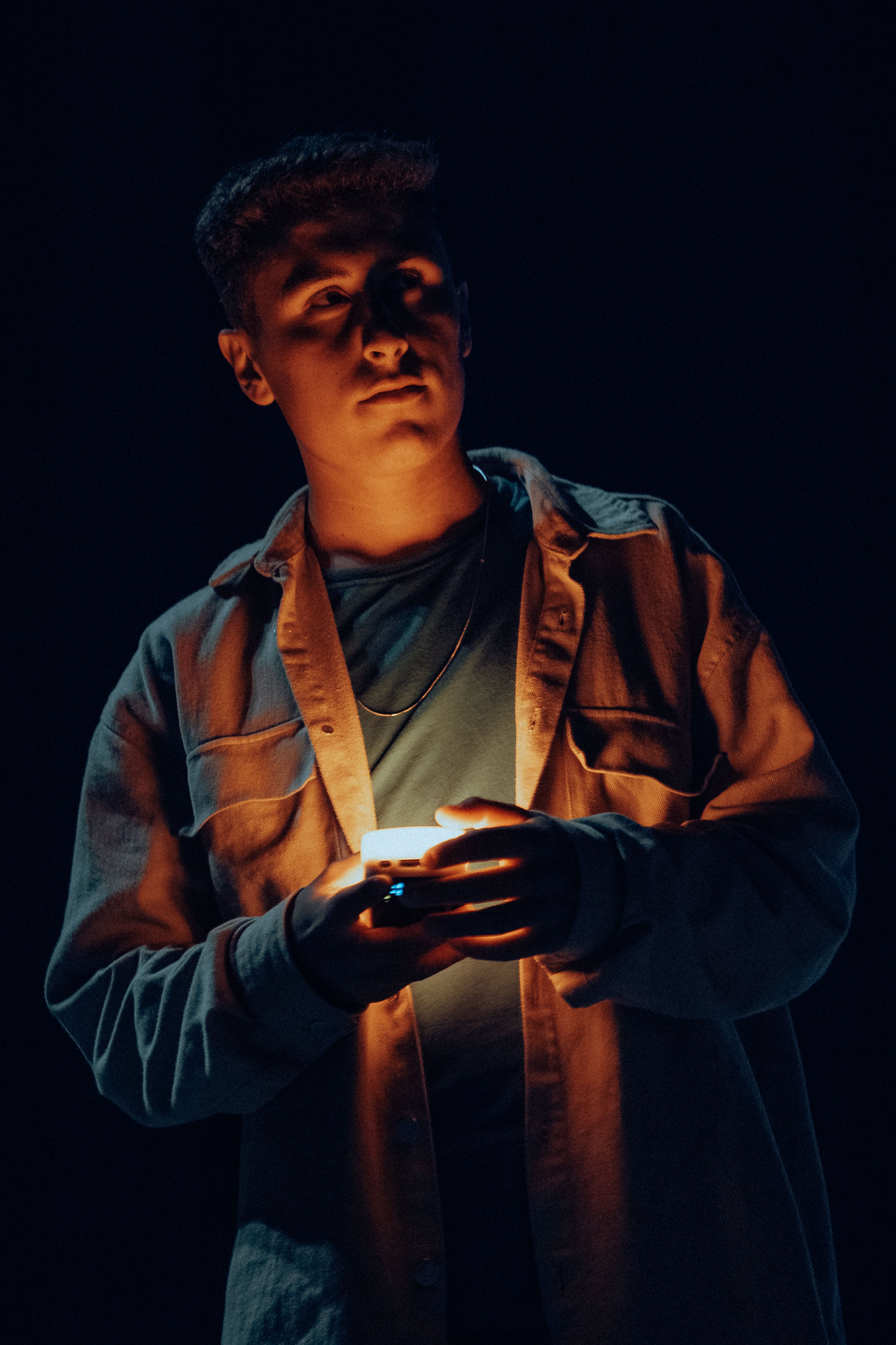 Young Man Holding a Flashlight in the Dark · Free Stock Photo
