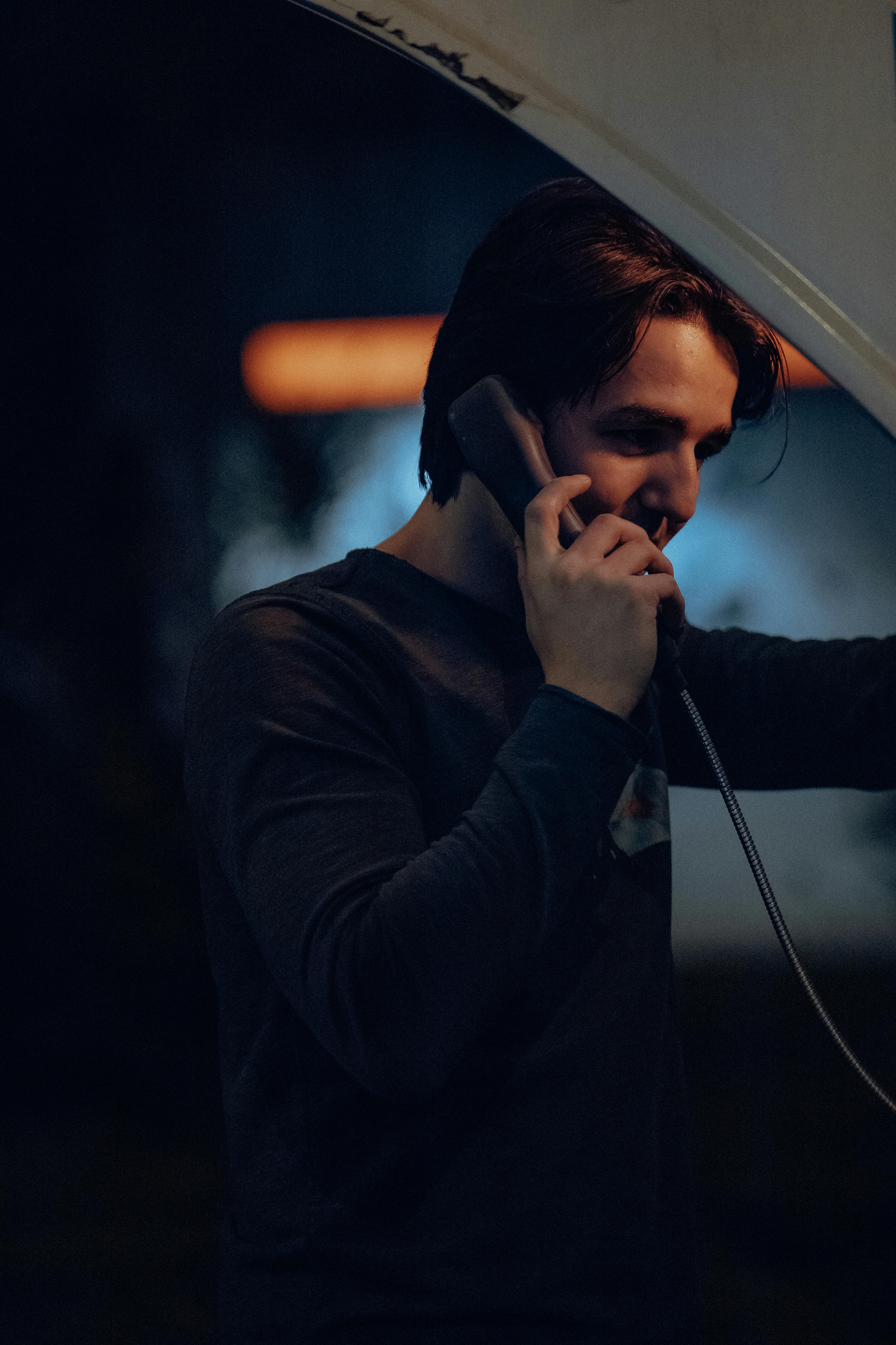 Young Man Using a Payphone · Free Stock Photo