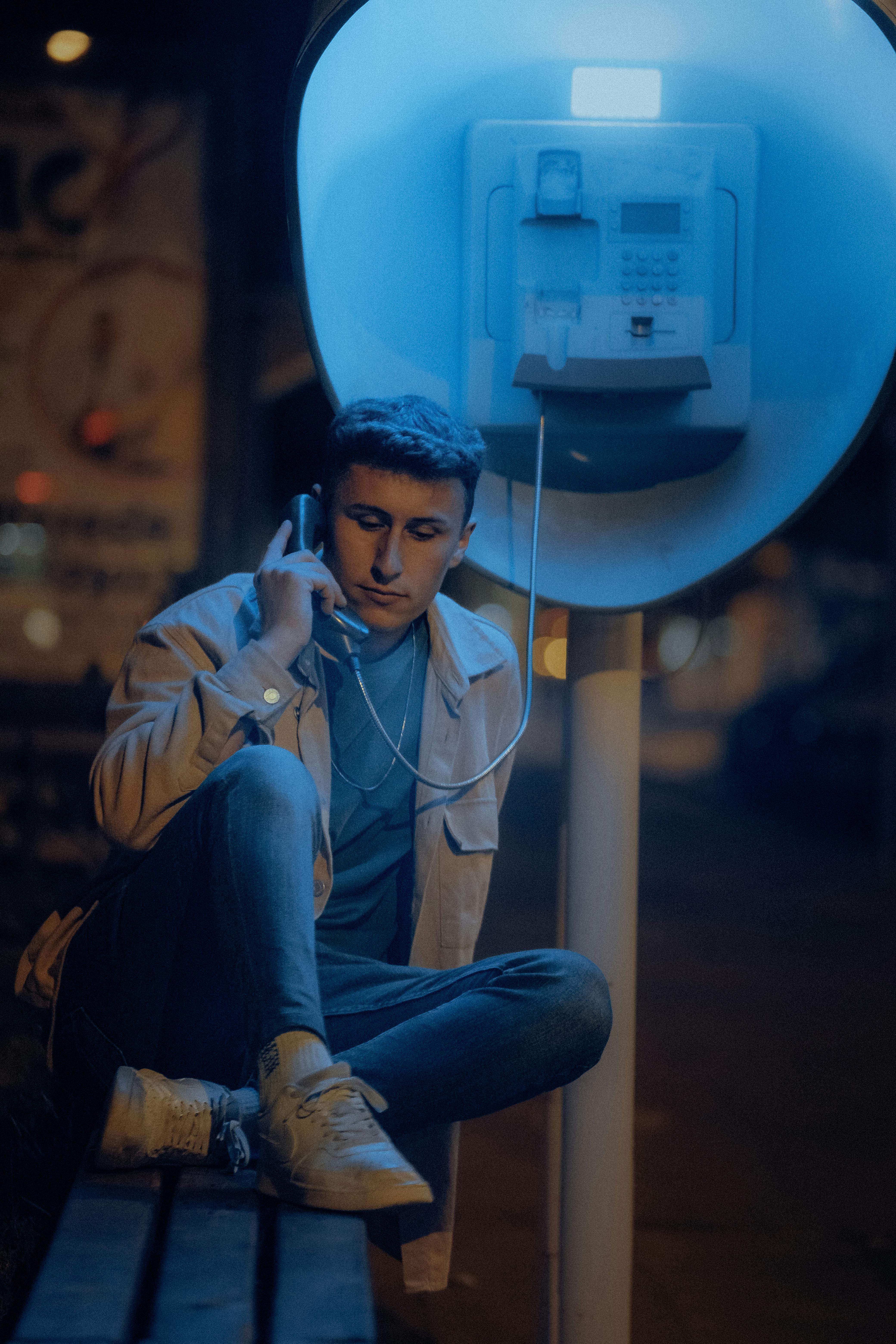 Young Man Using a Payphone · Free Stock Photo