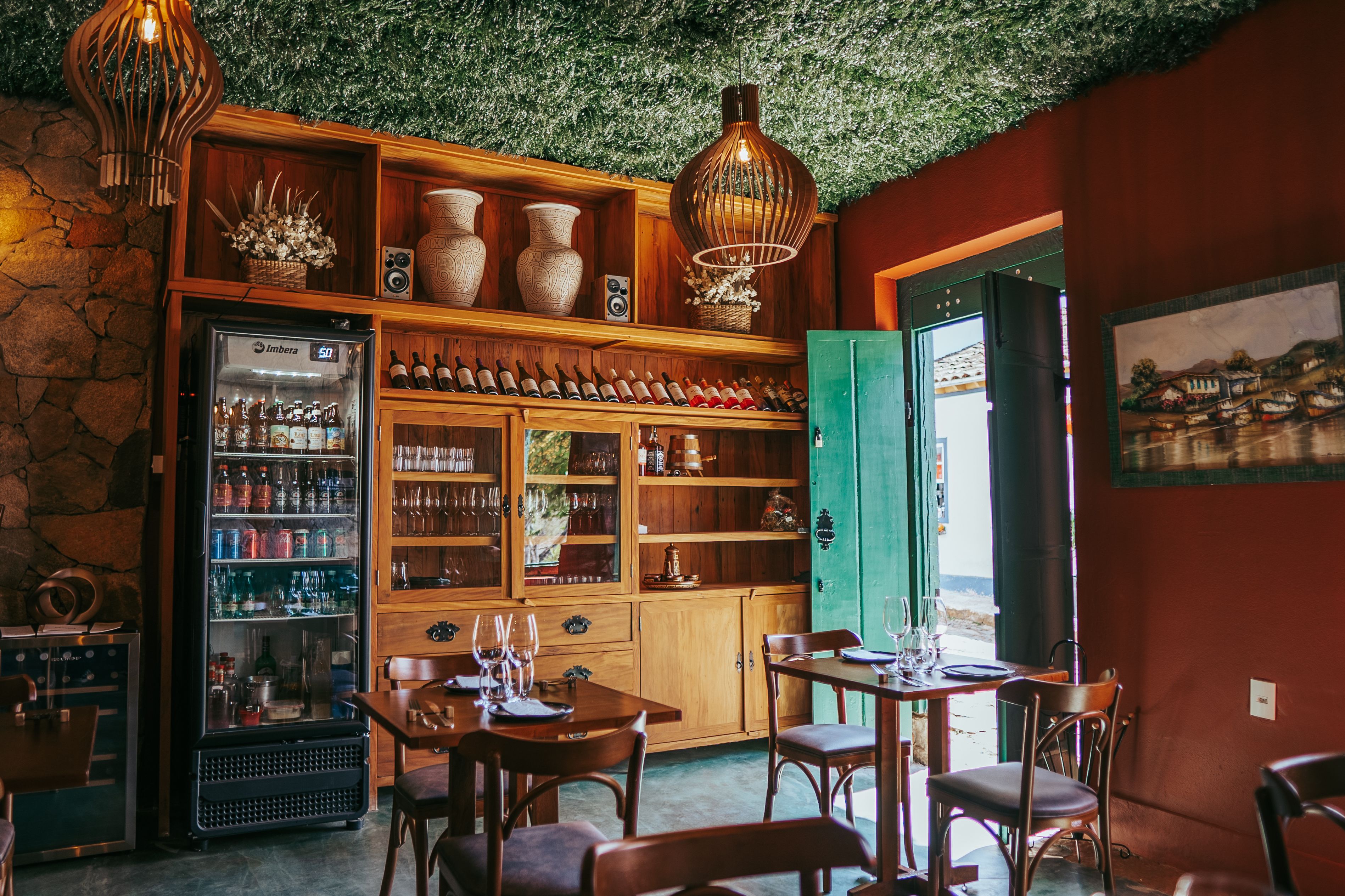 Tables near Furniture with Alcohol Bottles in Bar · Free Stock Photo