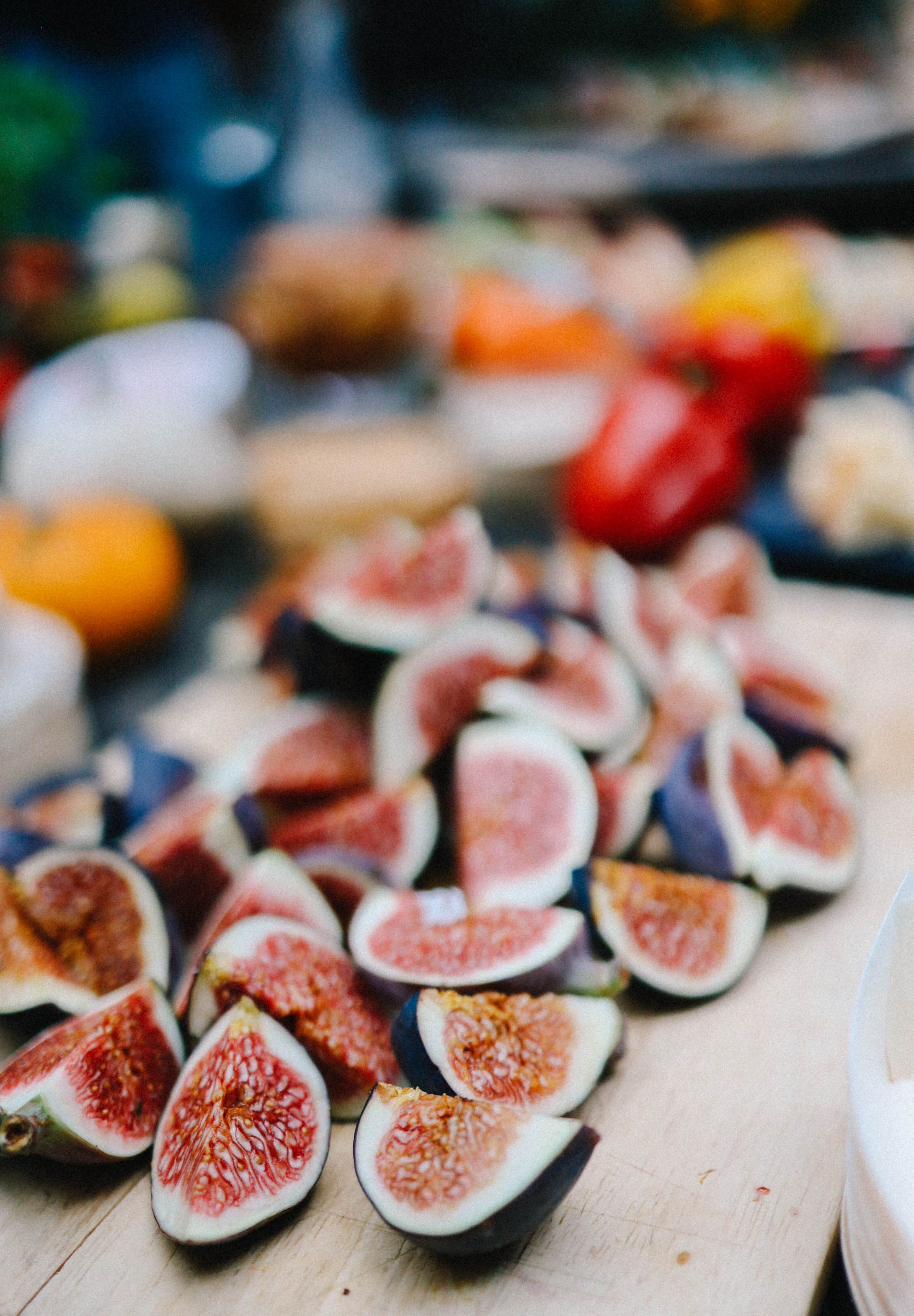 Figs and leaves on a table with a plant · Free Stock Photo