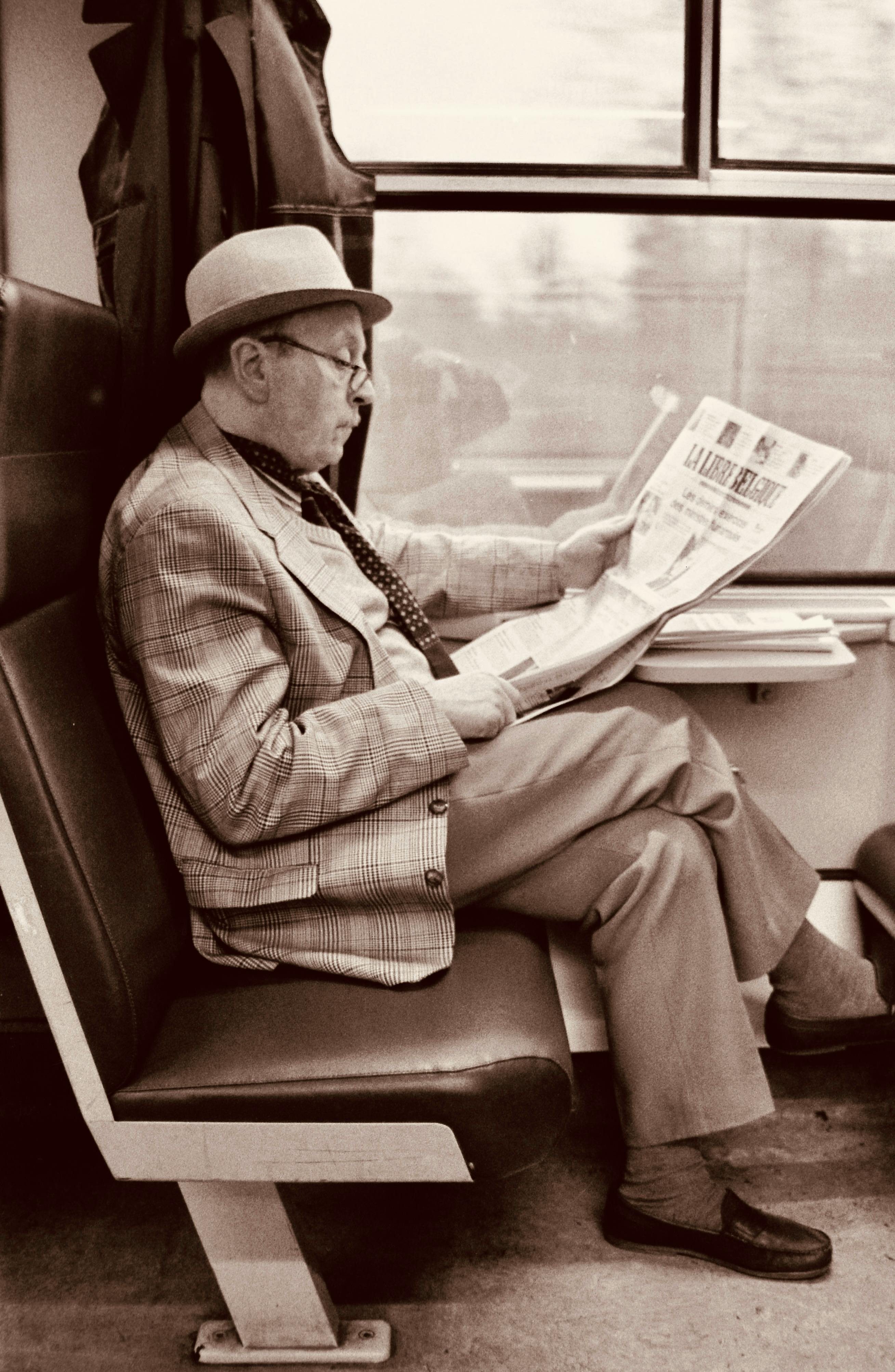 Sepia Toned Photograph of a Man Reading a Newspaper in a Train · Free ...