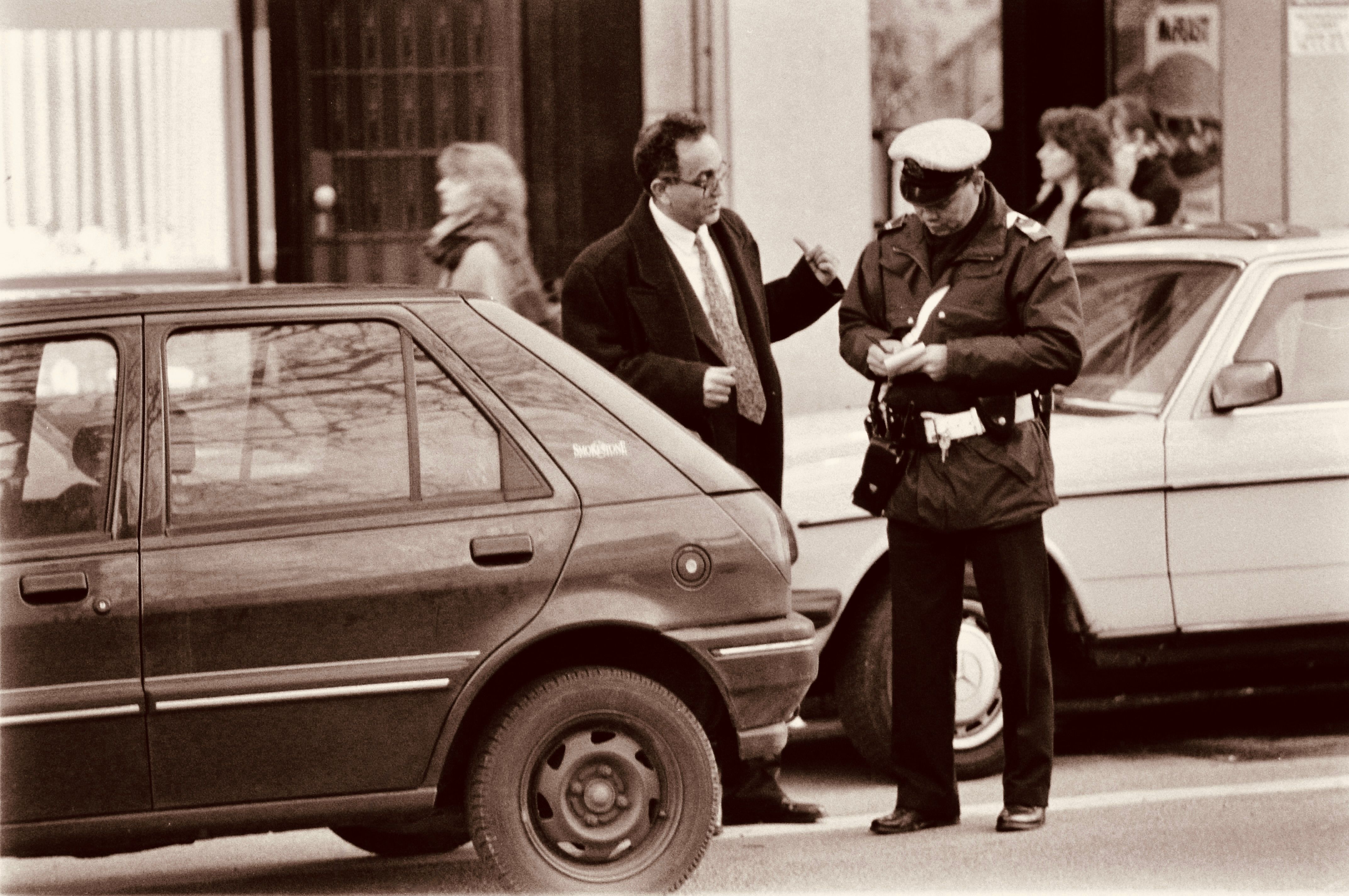 Two Police Men Standing Near Another Person Beside White and Blue ...