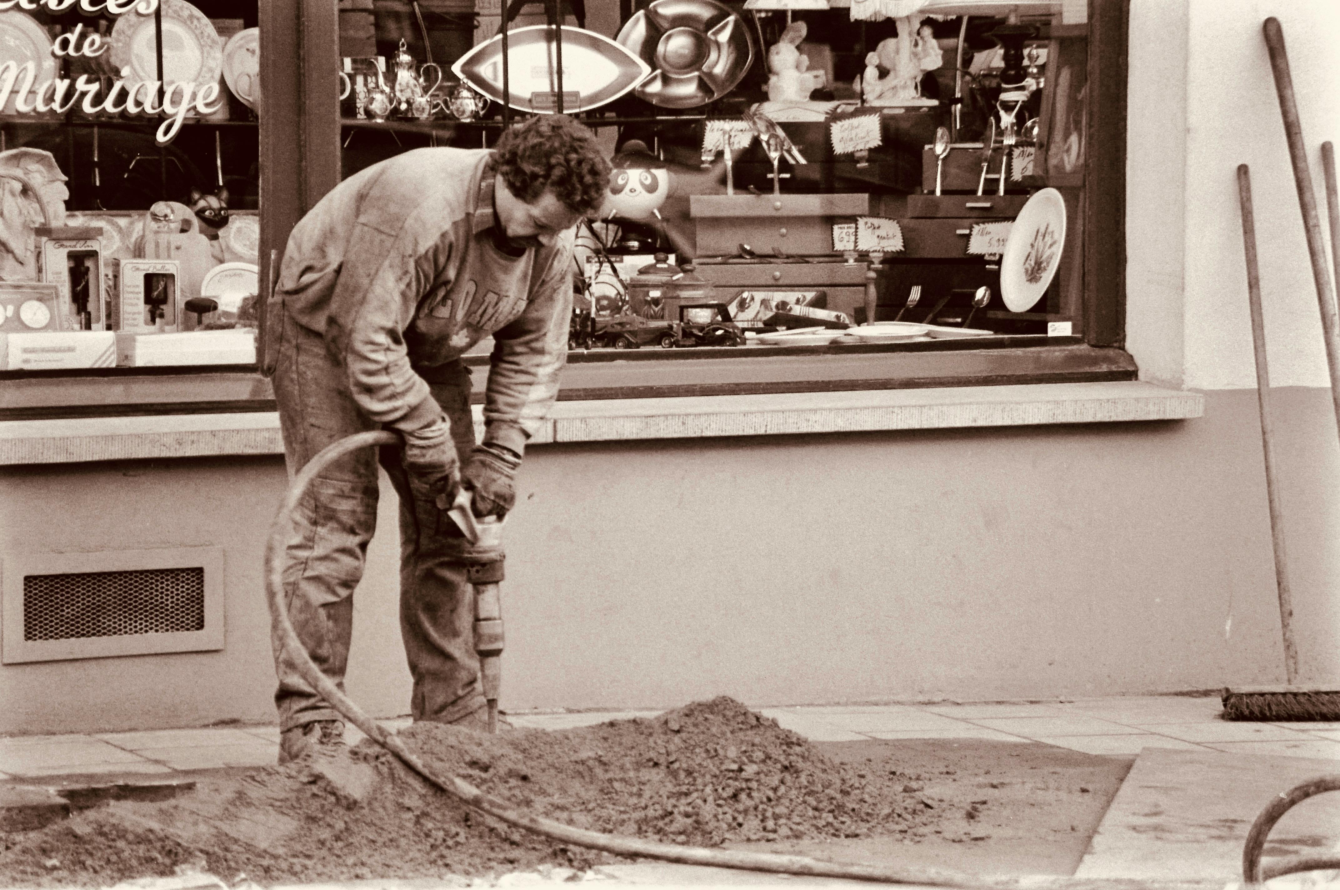 A Man Working on the Street in Sepia · Free Stock Photo