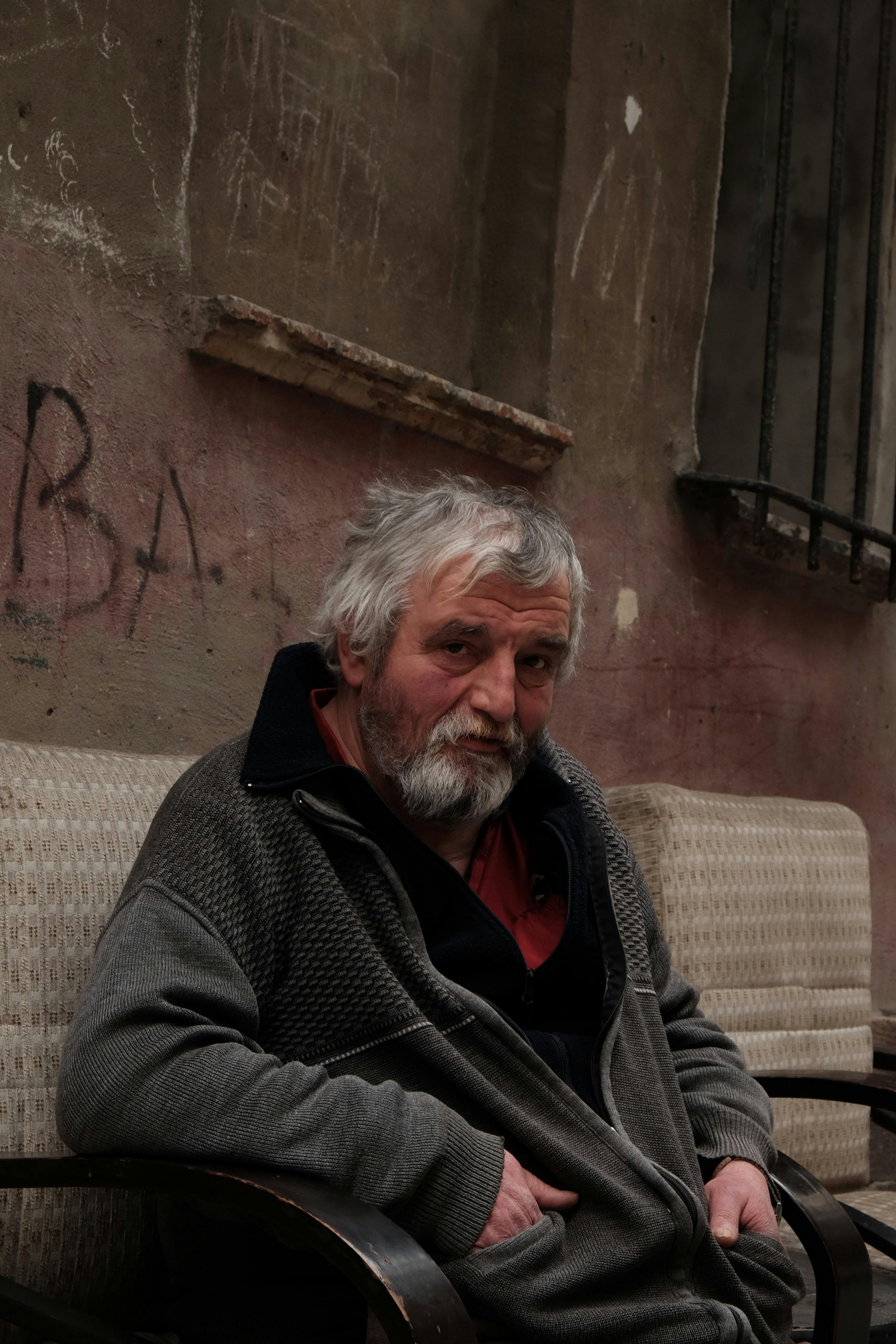 Unkempt Bearded Man Sitting on Street · Free Stock Photo