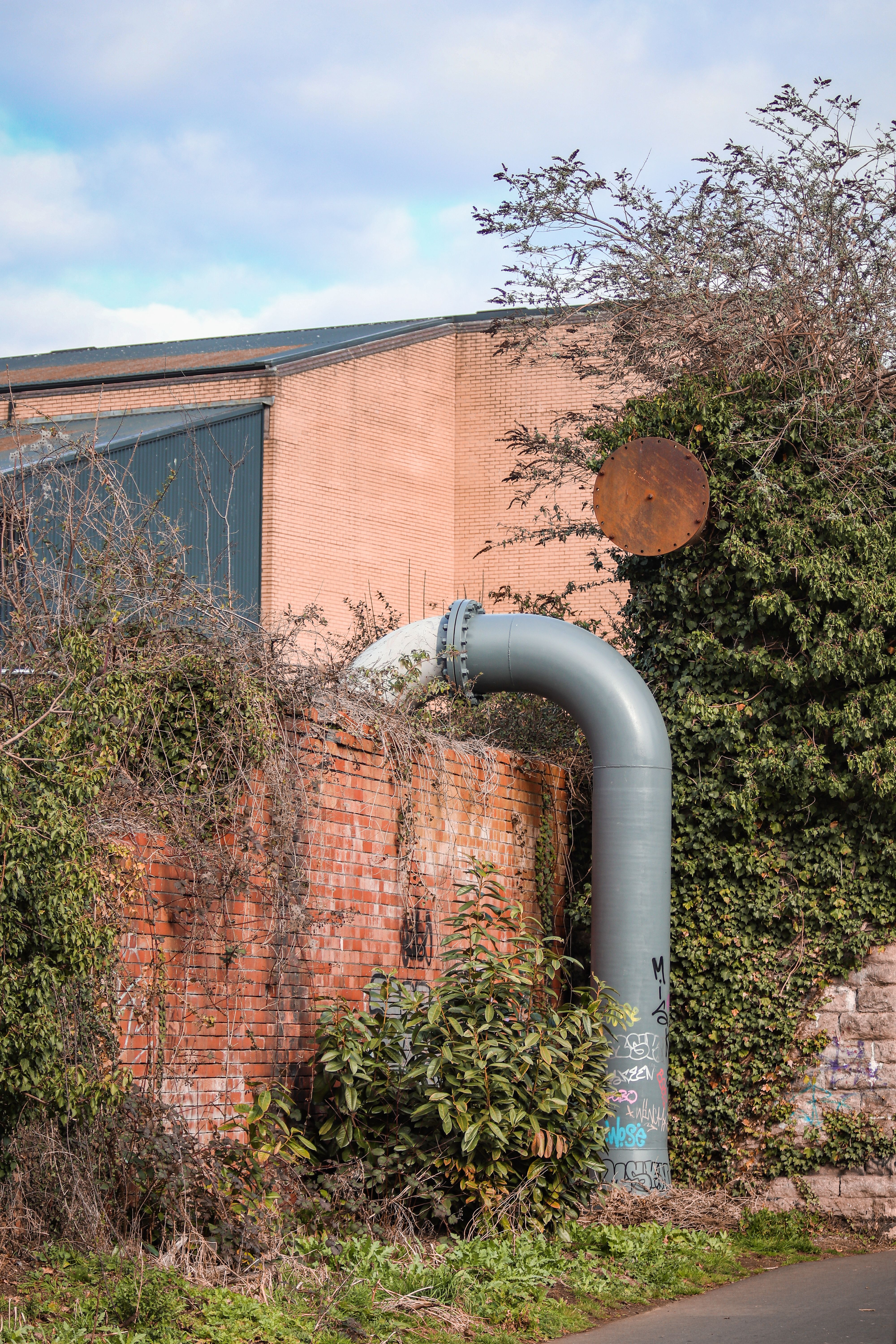 A Large Pipe Over a Brick Wall · Free Stock Photo