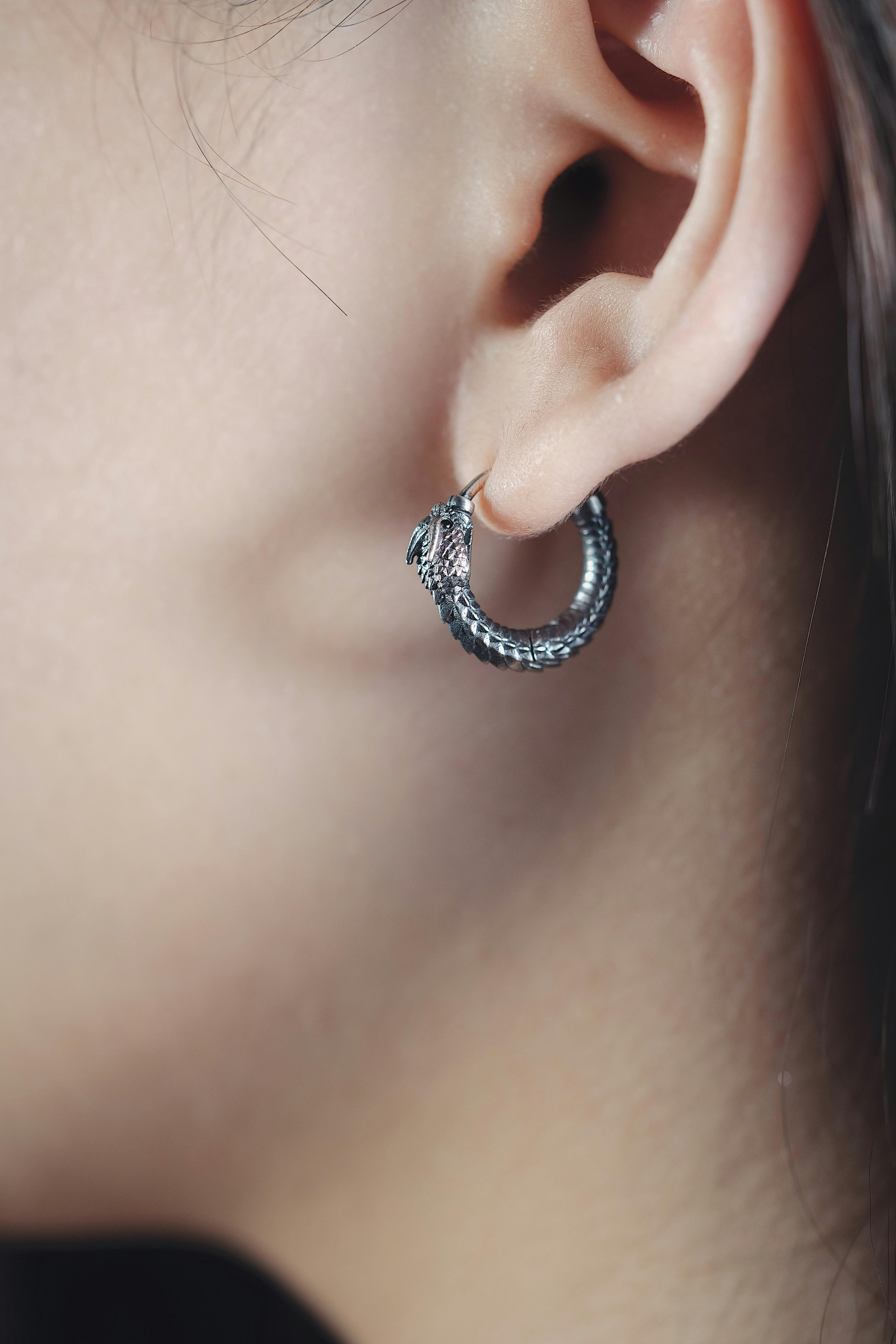 Silver Ouroboros Earring in Woman Ear · Free Stock Photo