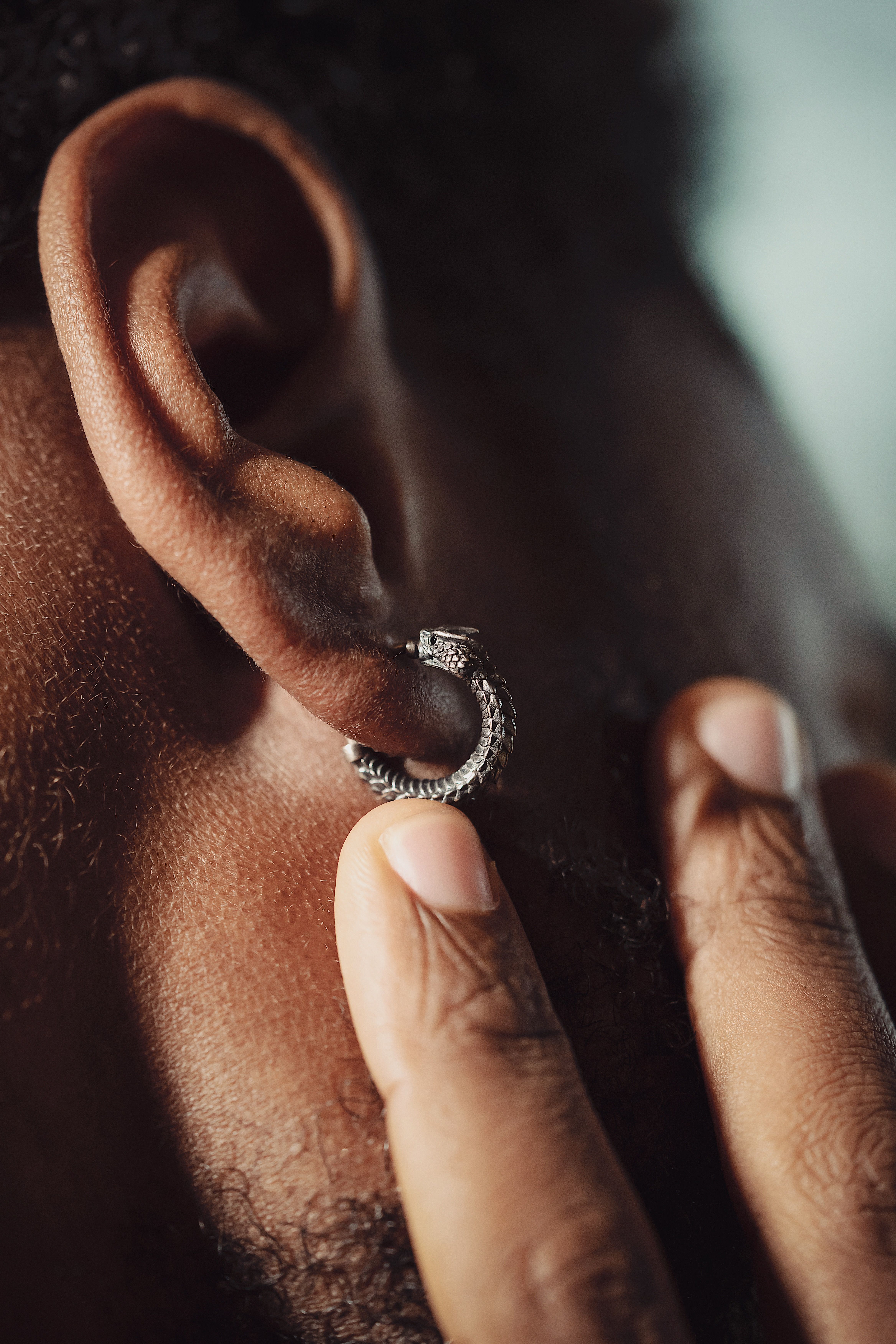 Man Touch Serpent Earring on his Ear · Free Stock Photo
