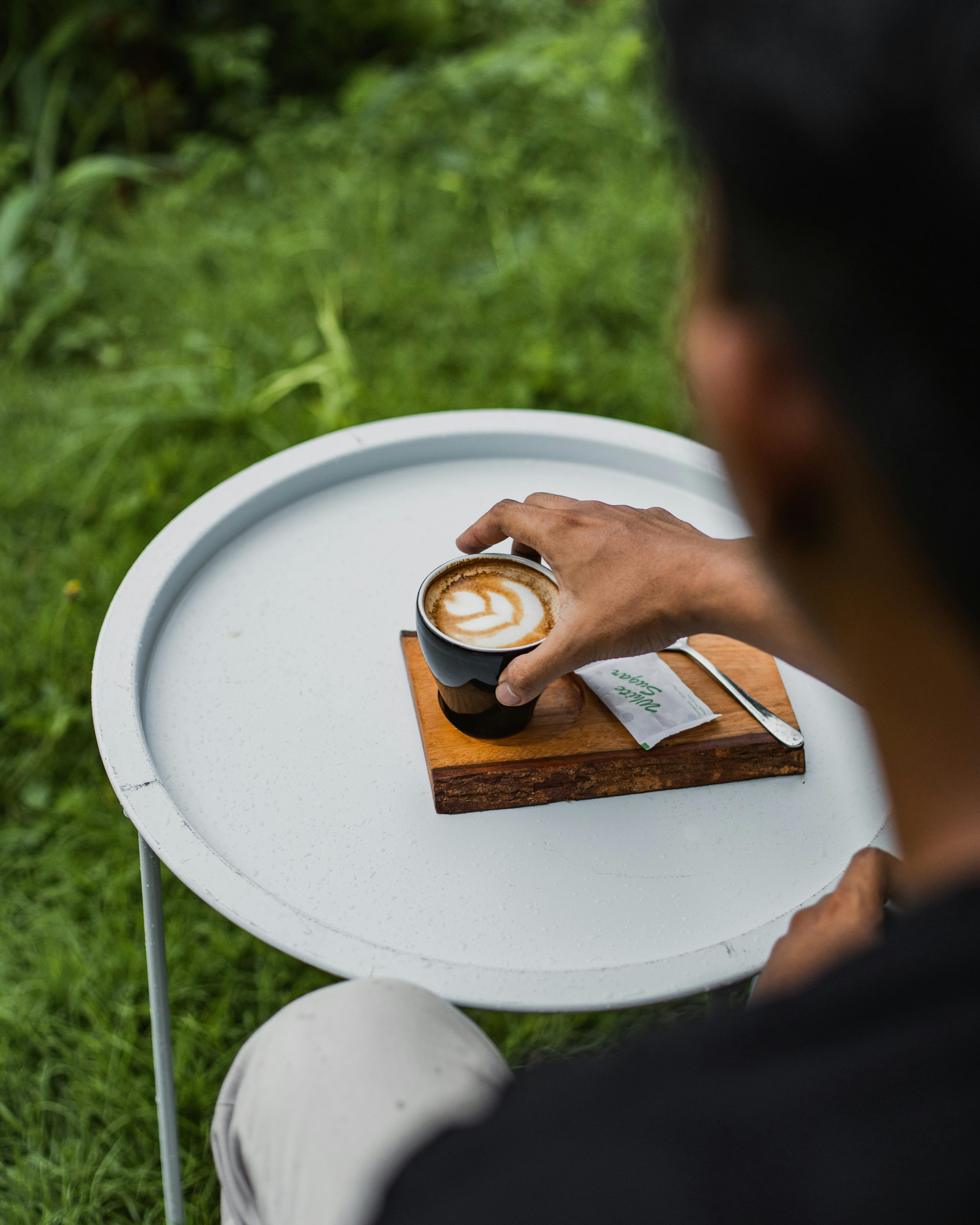 Man Hand on Coffee Cup on Table · Free Stock Photo