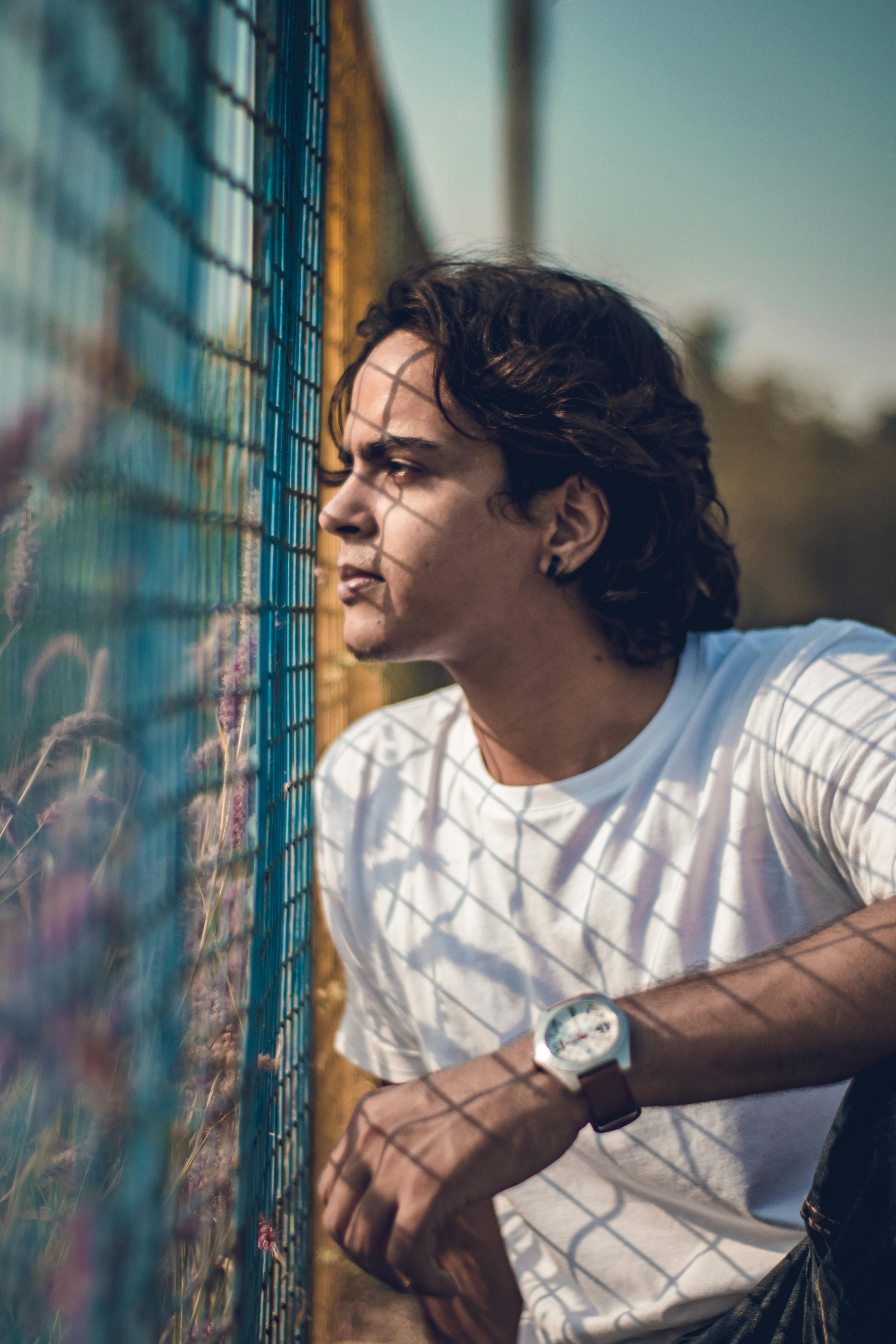 Selective Focus Photography of Man Sitting Beside Blue Railings · Free ...