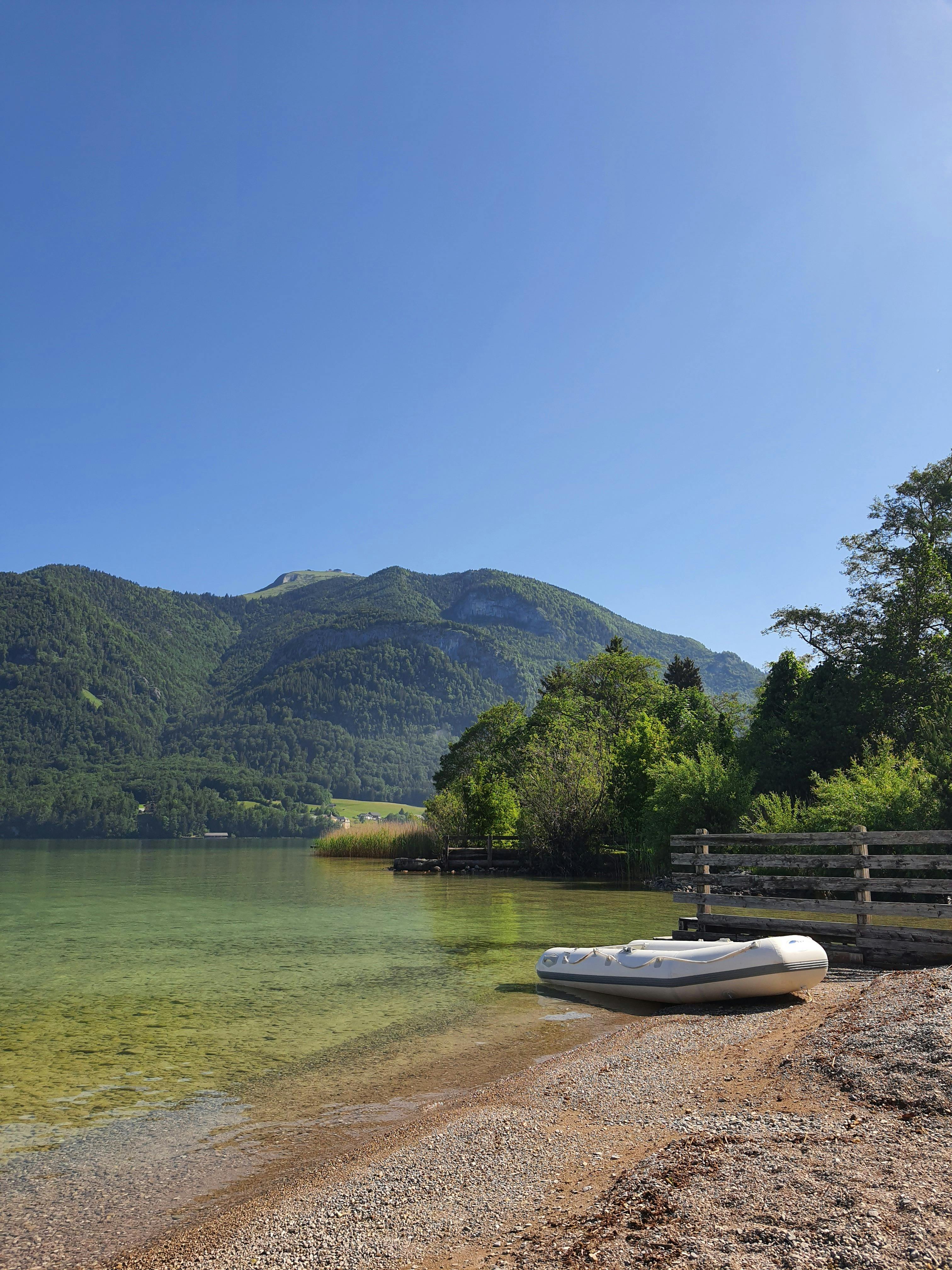 Boat floating on blue tranquil lake in verdant highlands · Free Stock Photo