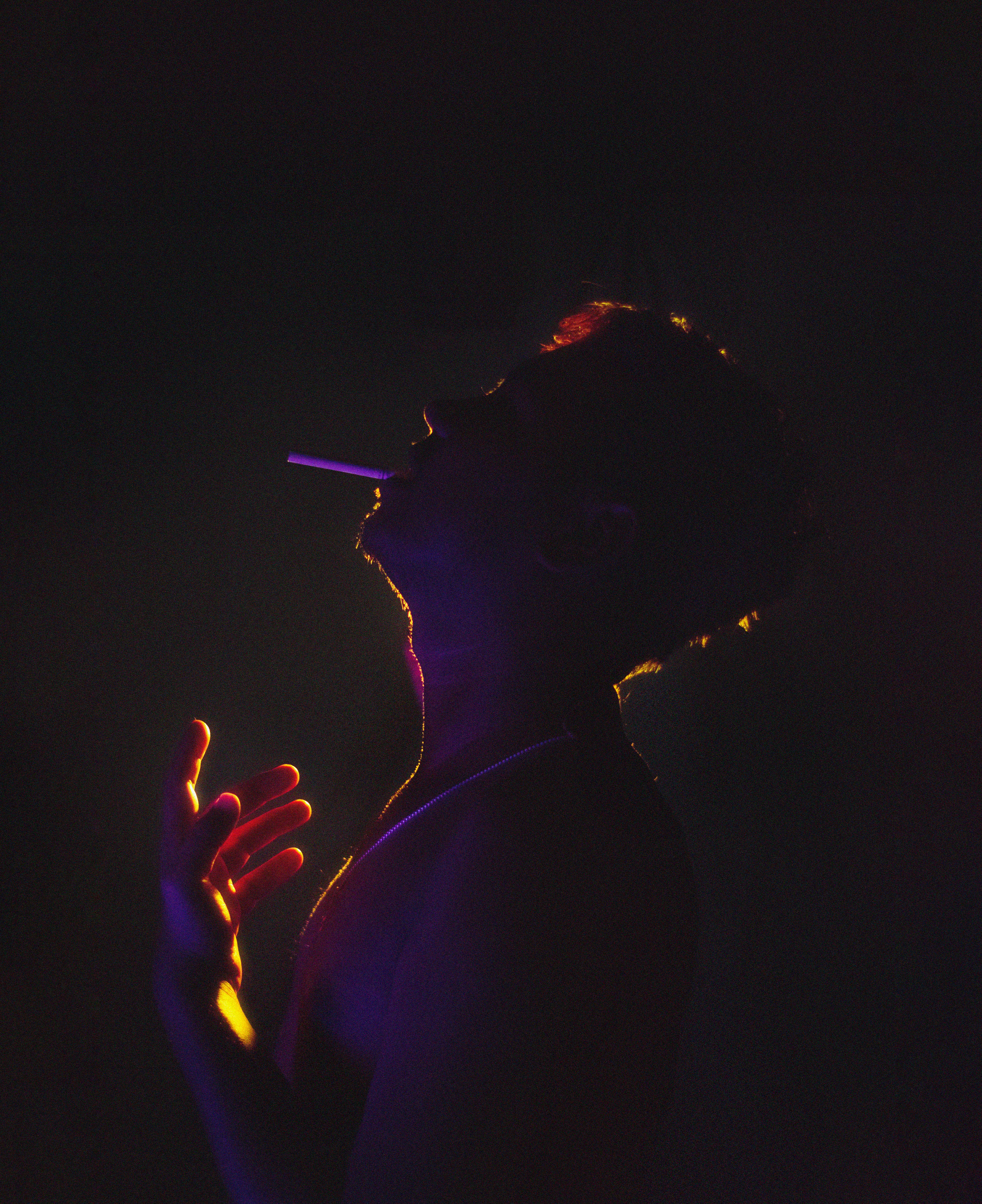 A man smoking a cigarette in the dark · Free Stock Photo