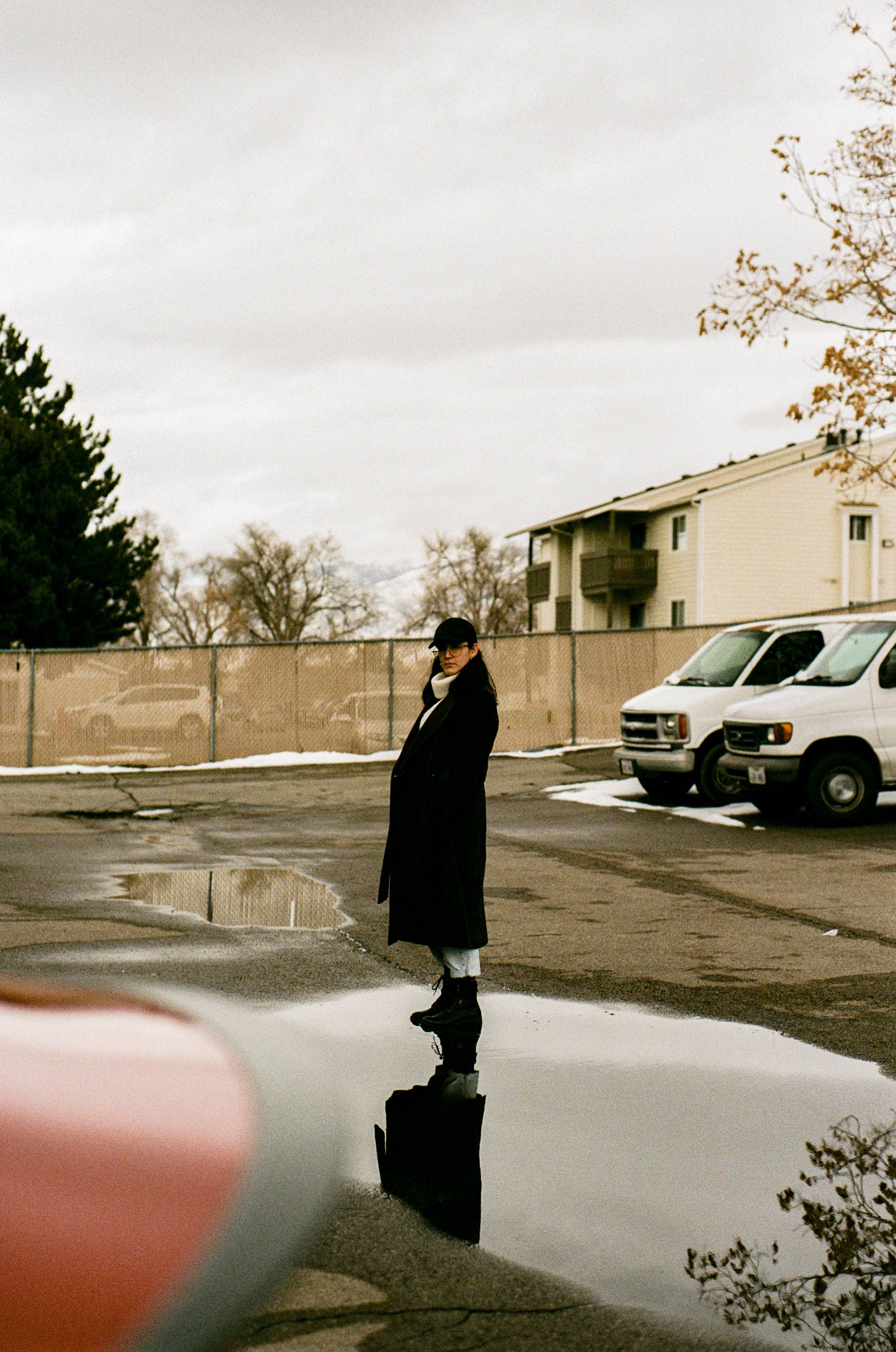 Woman Standing in a Puddle on a Parking Lot · Free Stock Photo