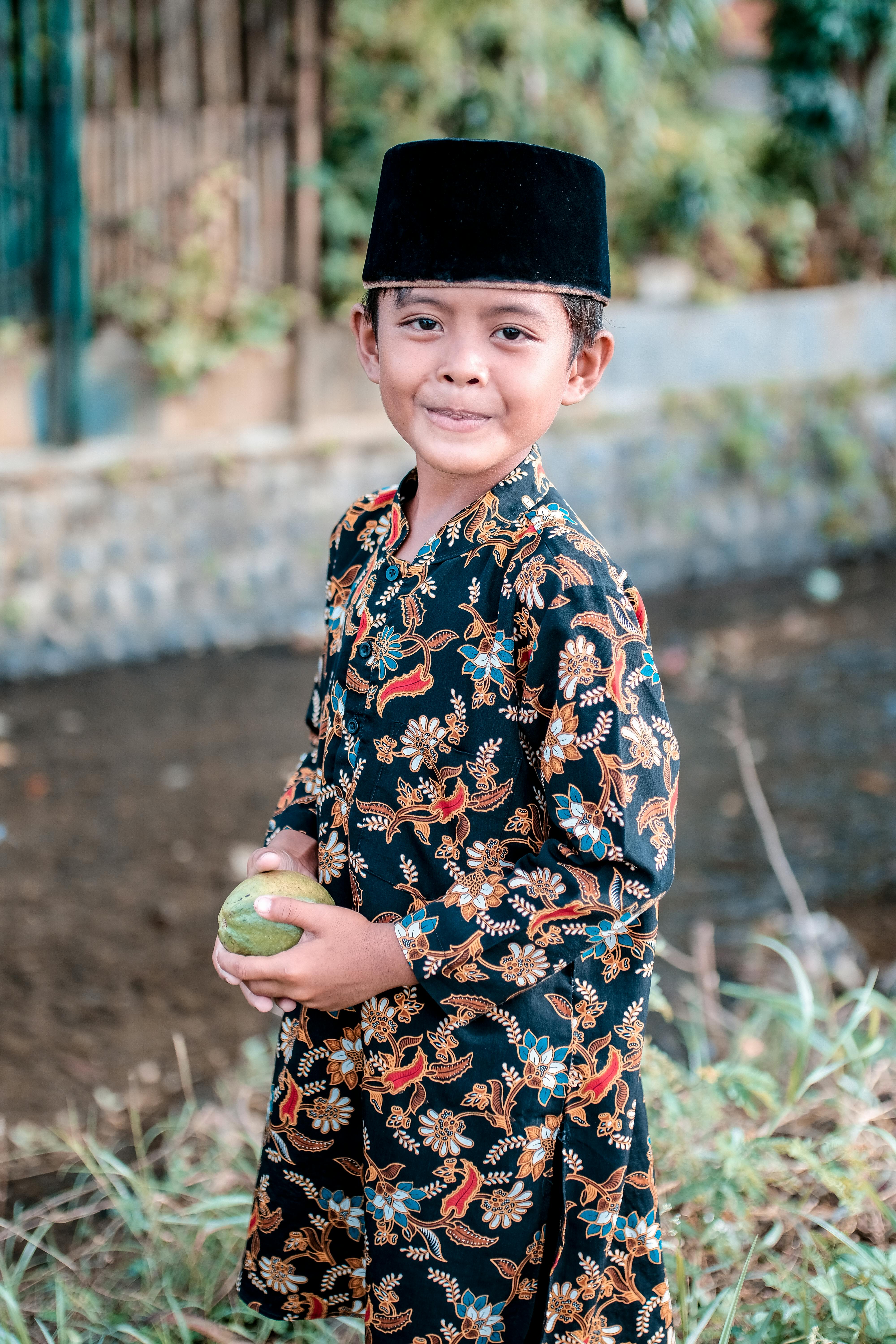 Cute Boy in Traditional Costume and Headwear Outdoors · Free Stock Photo