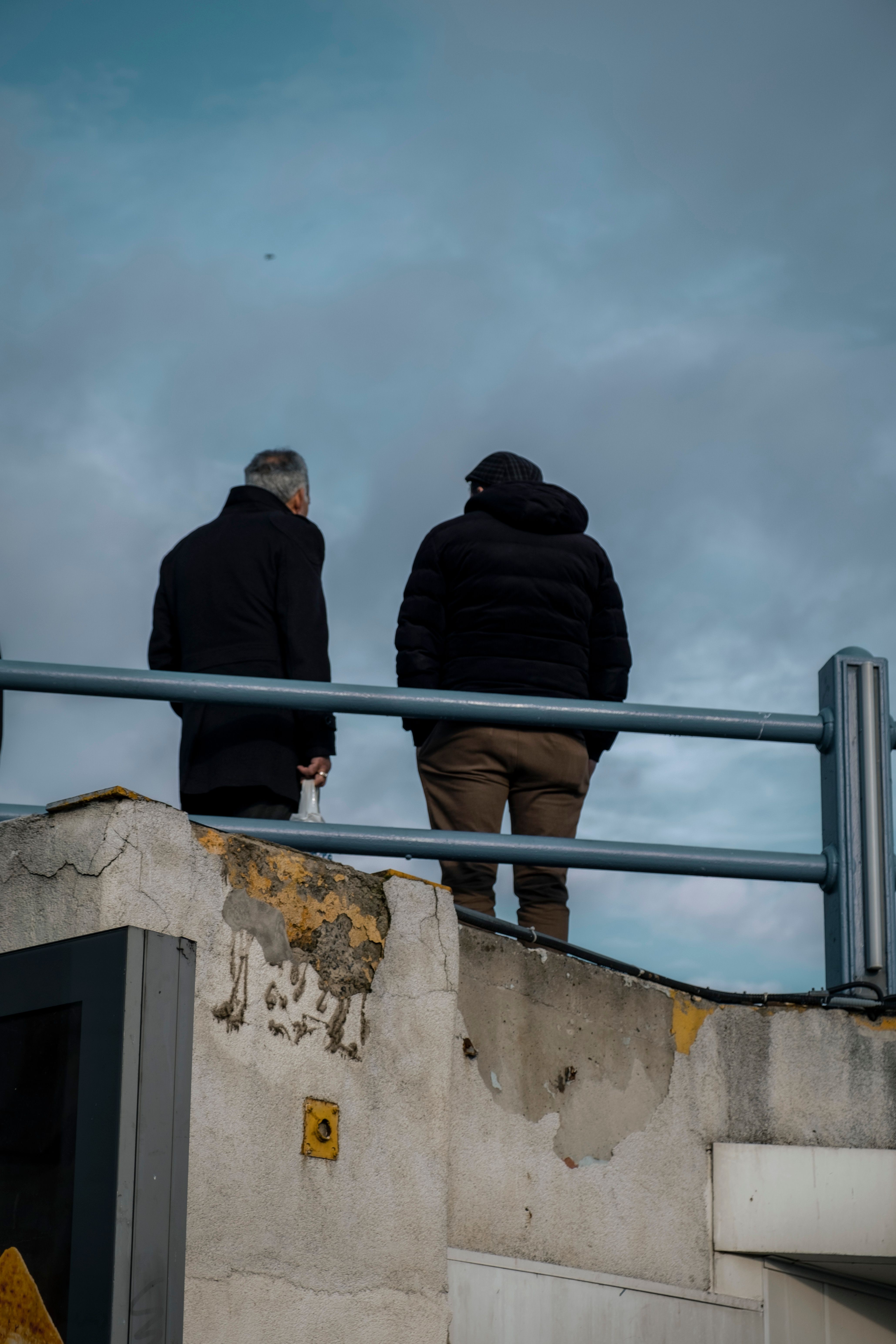 Low Angle Shot Two Men Standing on a Platform next to the Railing ...