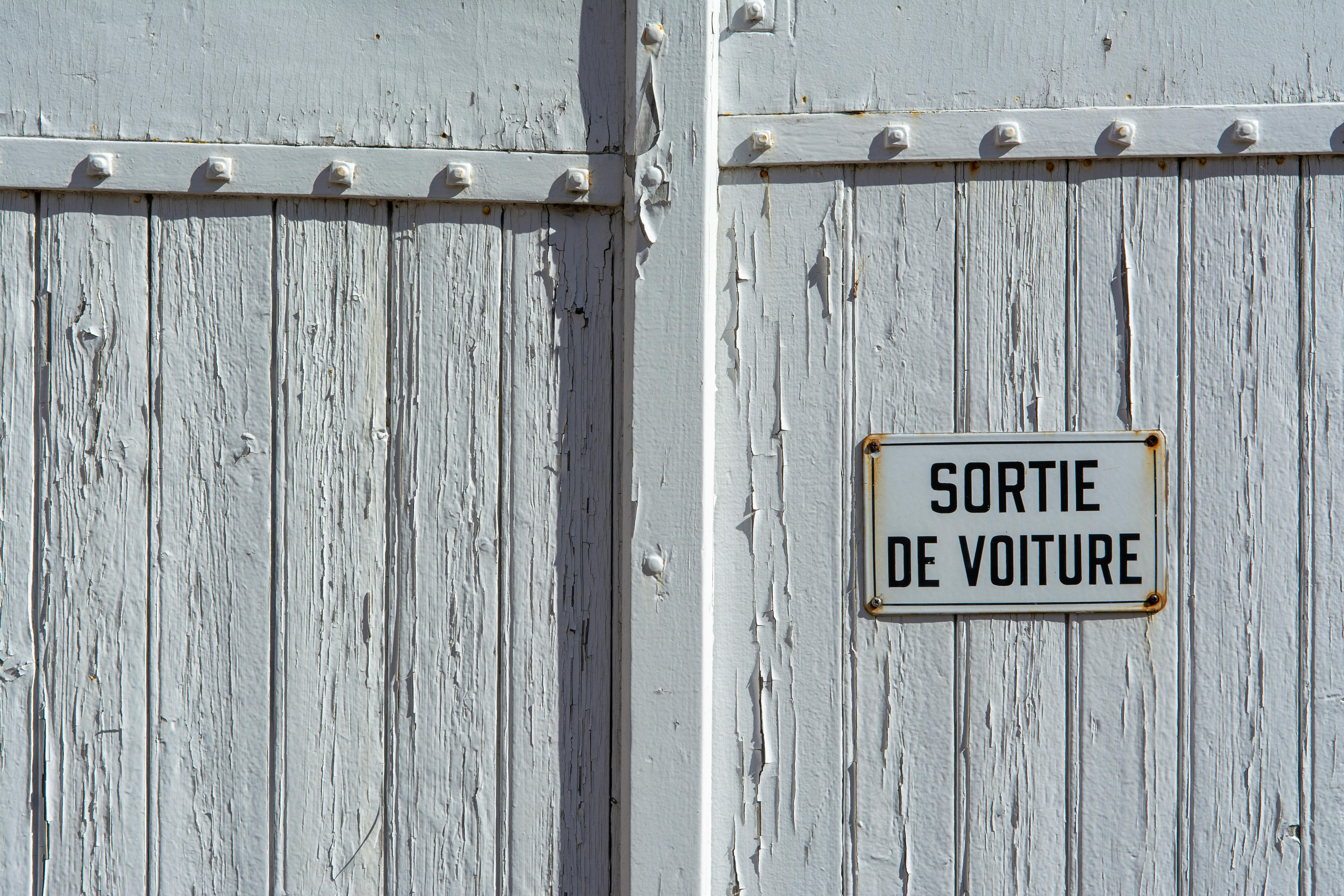 Board with Text in French on White Wall · Free Stock Photo