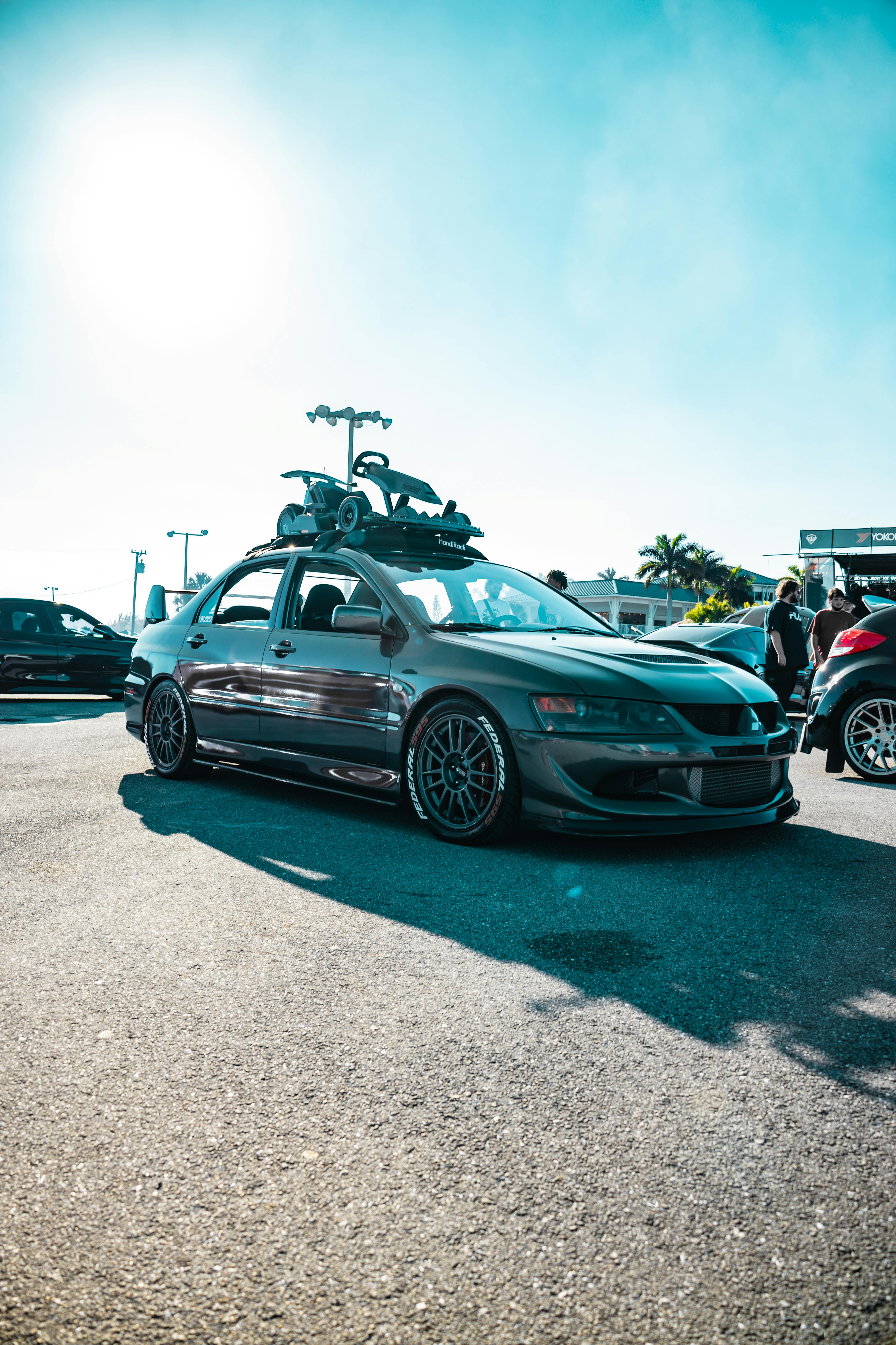 A car with a bike on top of it parked in a parking lot · Free Stock Photo