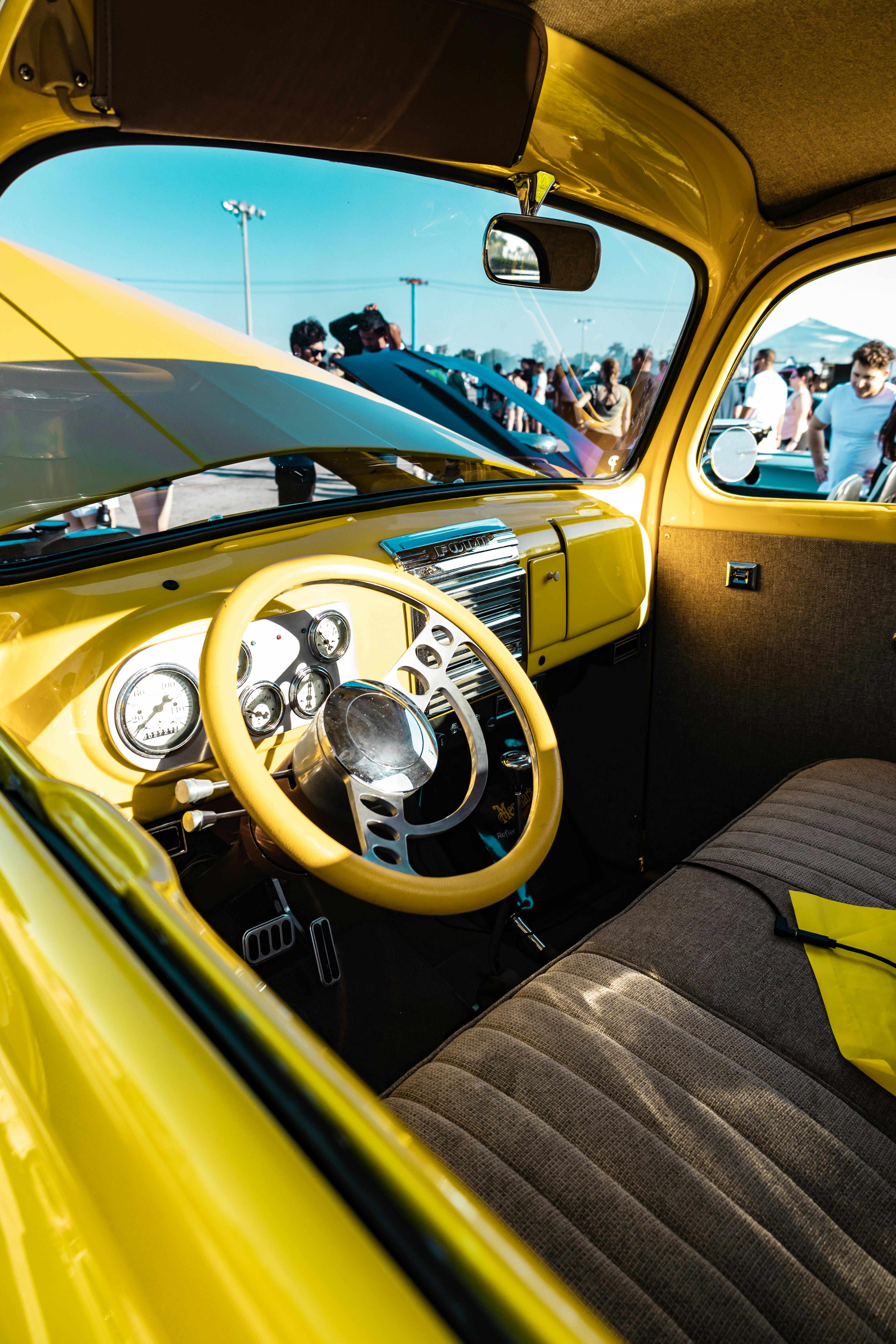 The interior of a yellow car with a steering wheel · Free Stock Photo