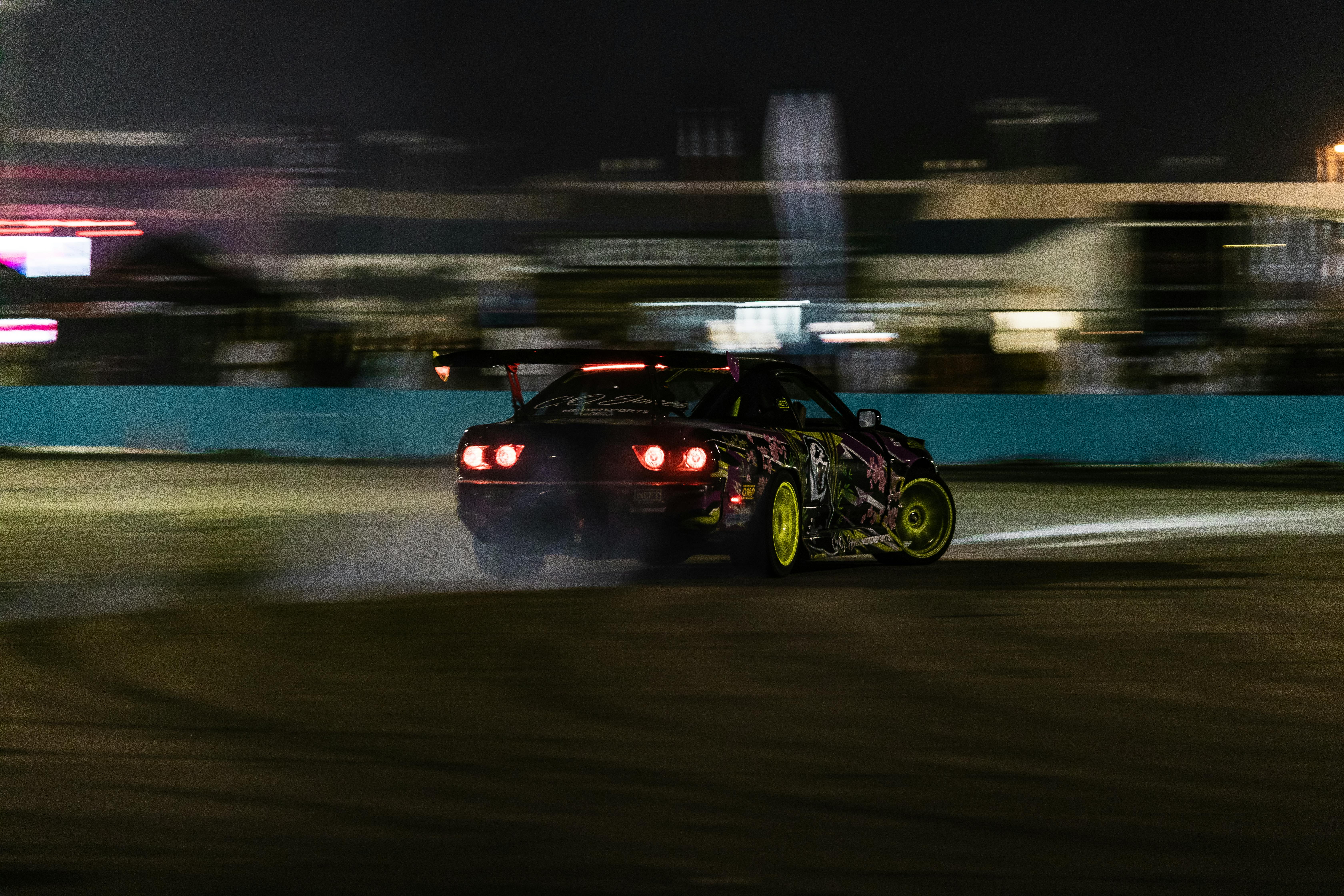 A car is driving on the track at night · Free Stock Photo