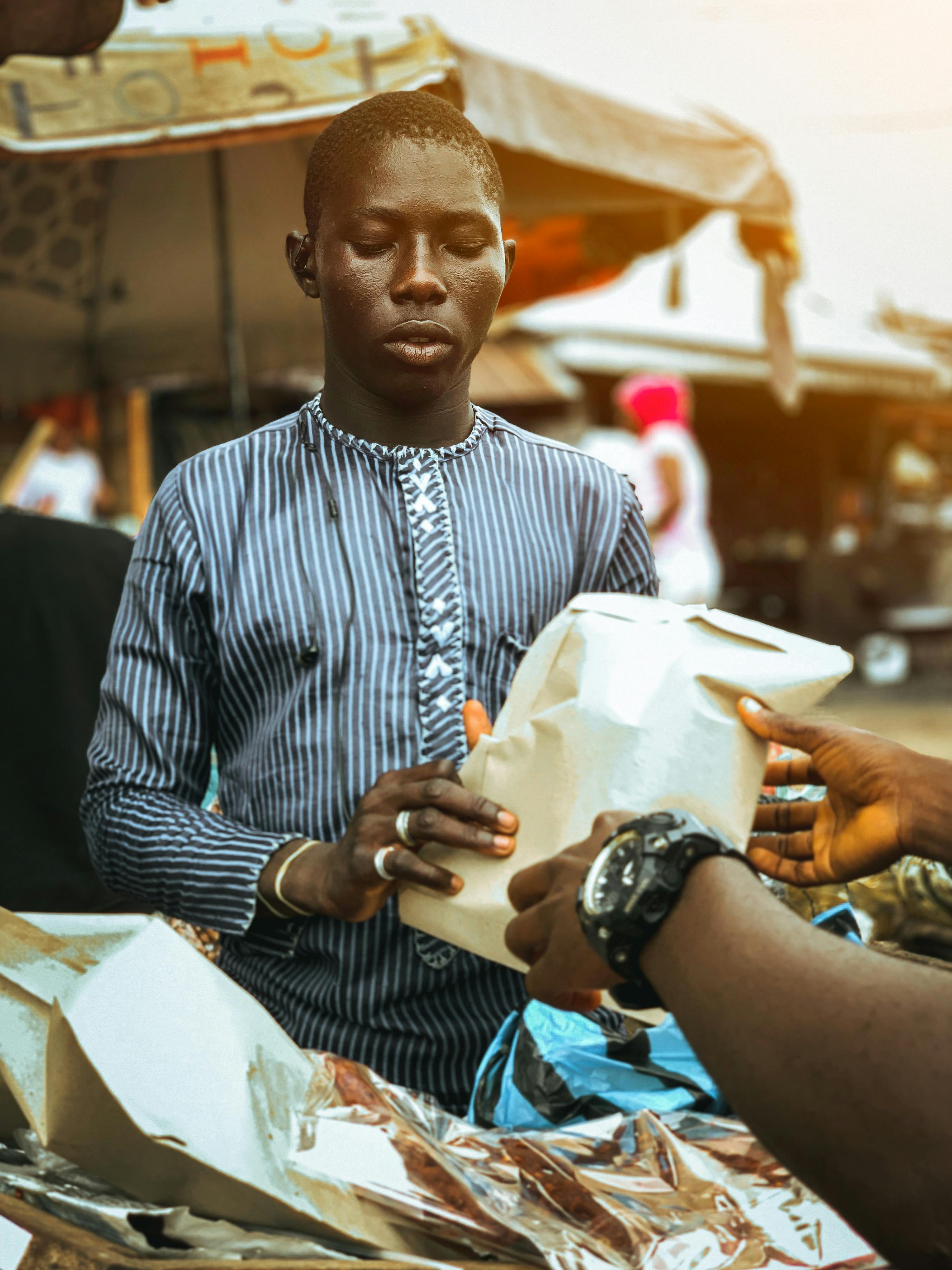 Street Vendor Selling Package Wrapped in Paper · Free Stock Photo