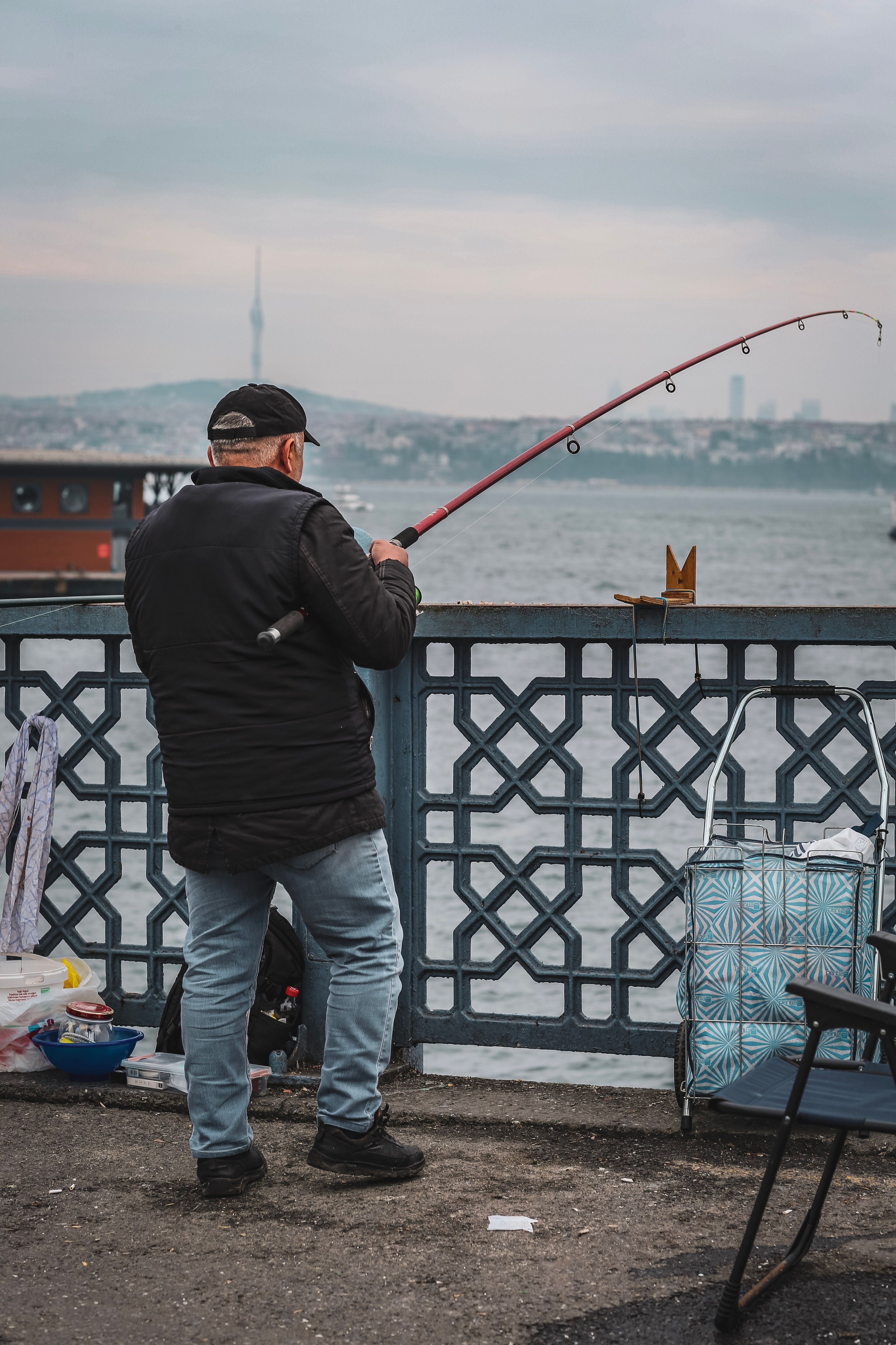 Man Fishing from Bridge in City · Free Stock Photo